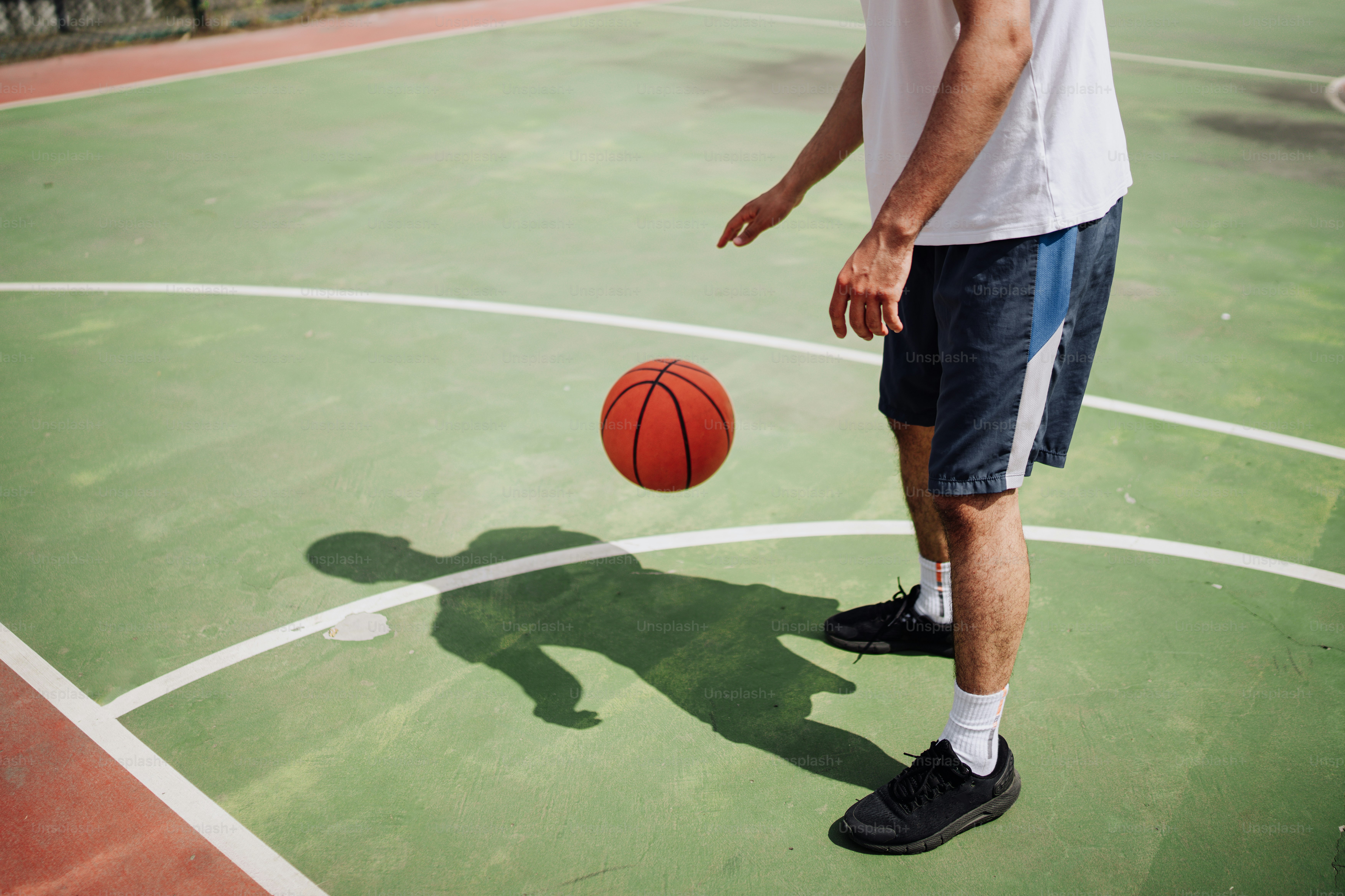 A man standing on a basketball court holding a basketball photo ...