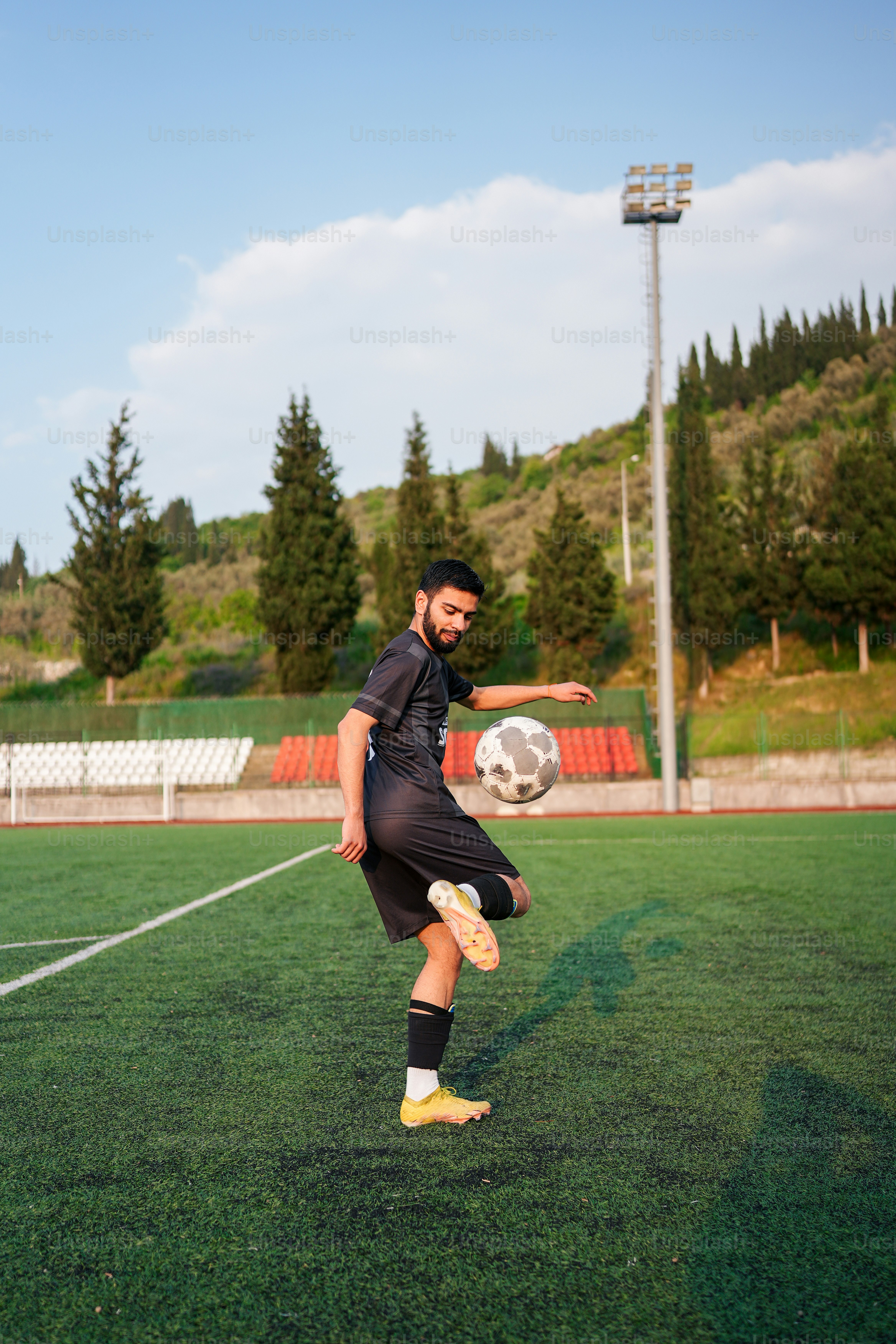 A man kicking a soccer ball on a field photo – Football Image on Unsplash