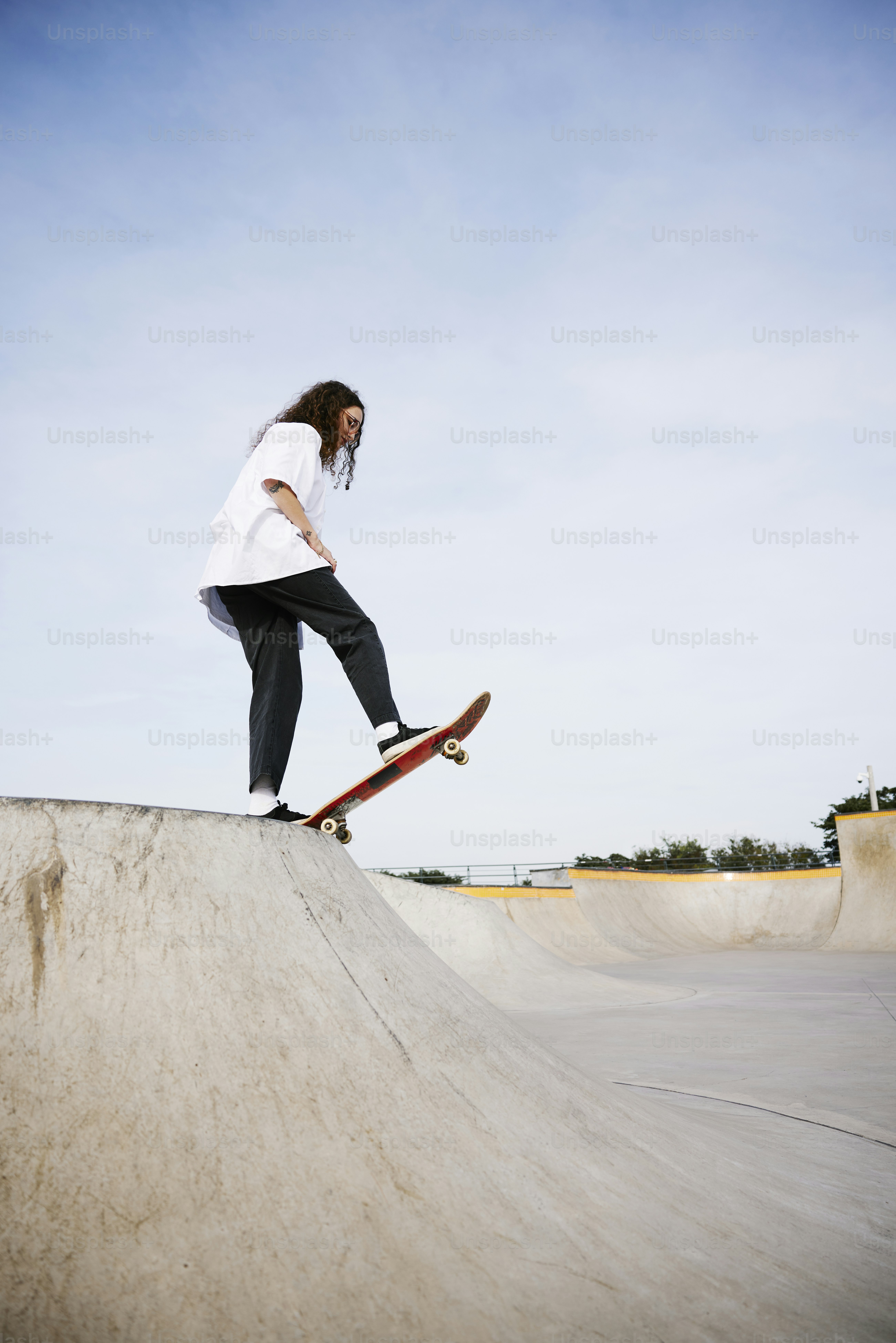 A man riding a skateboard up the side of a ramp photo – Skater girl ...