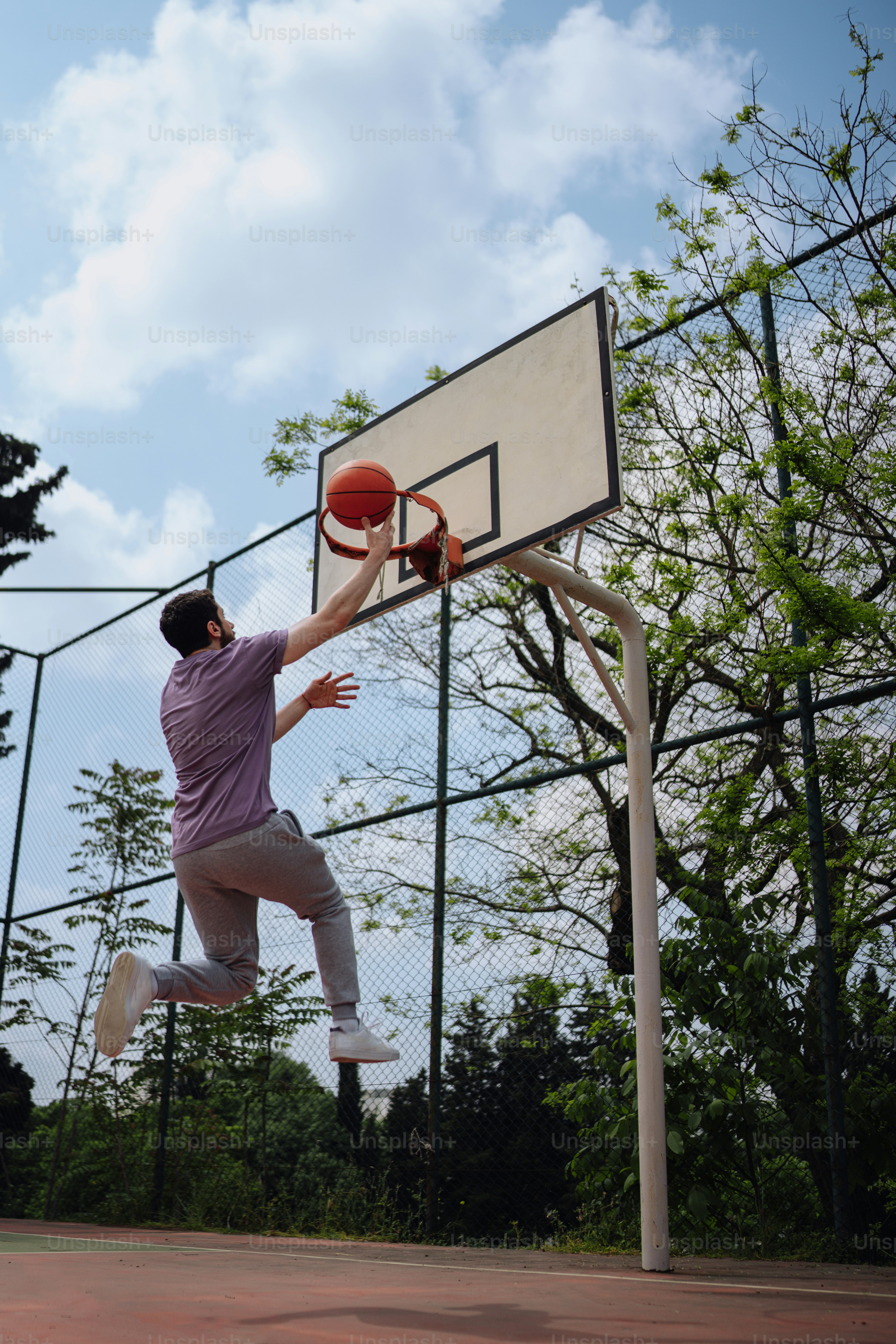 A man jumping up into the air to dunk a basketball photo – Basketball ...