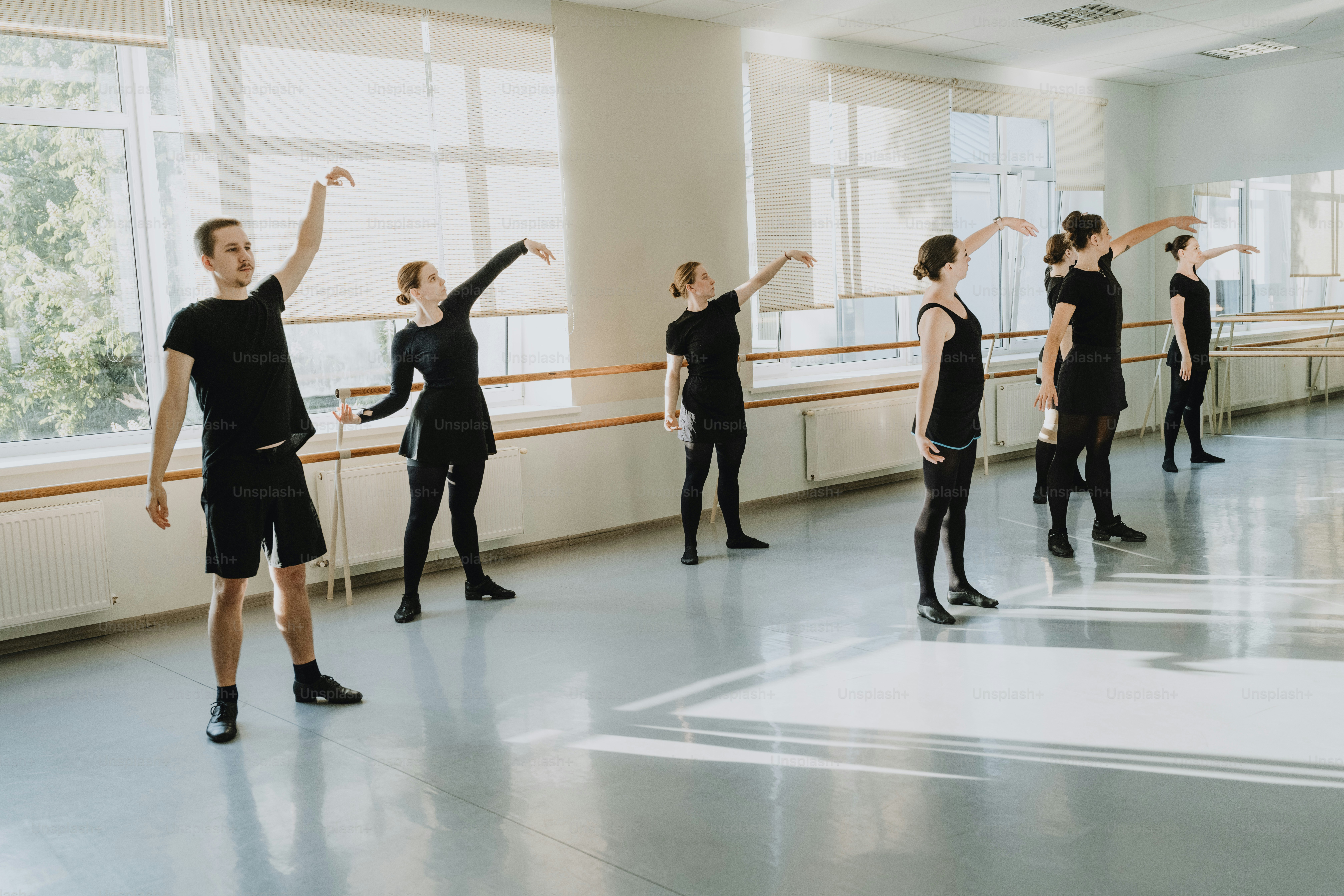 A group of people standing in a room photo – People dancing Image on ...