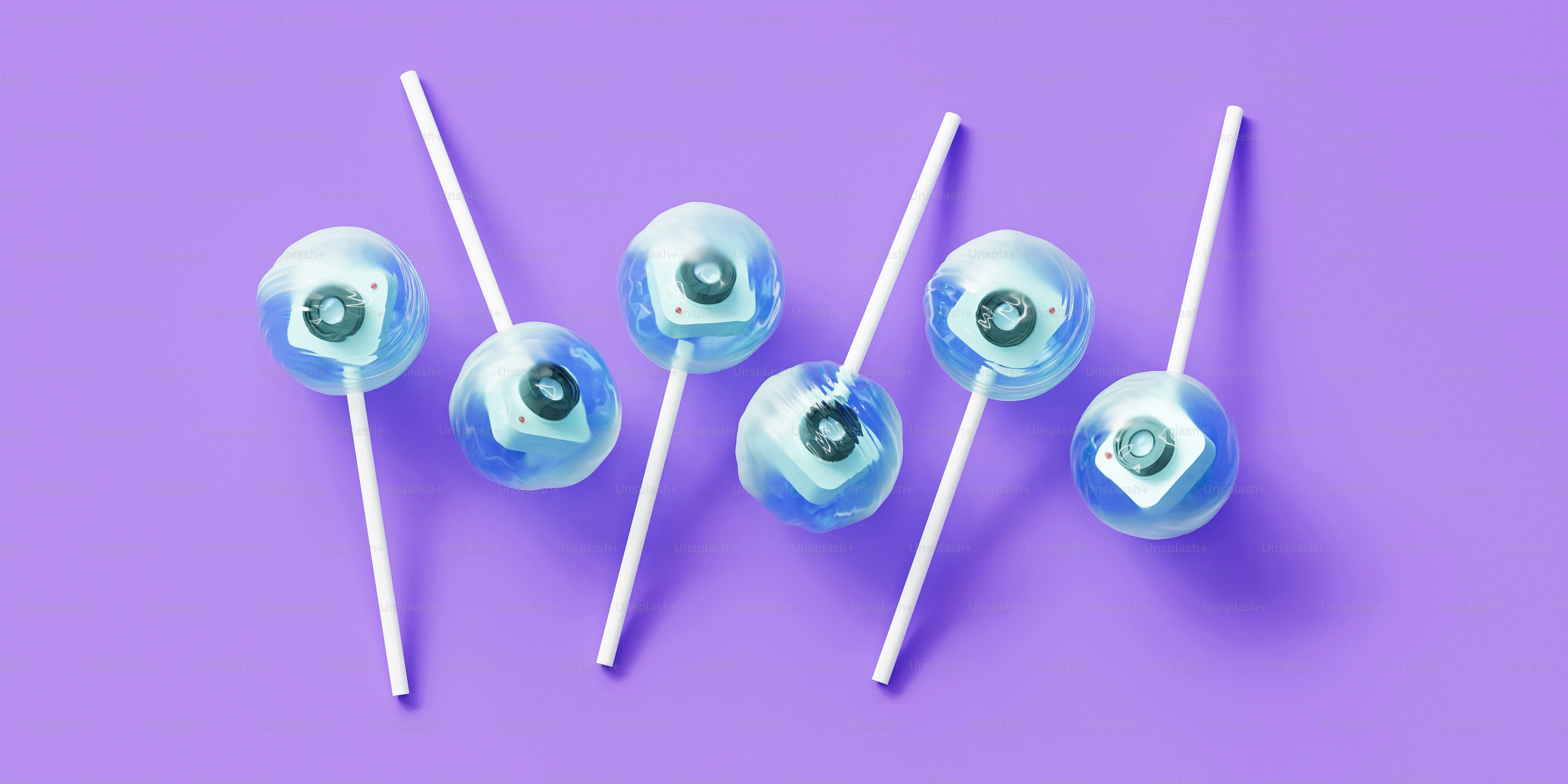 A group of lollipops sitting on top of a purple surface photo – Camera ...