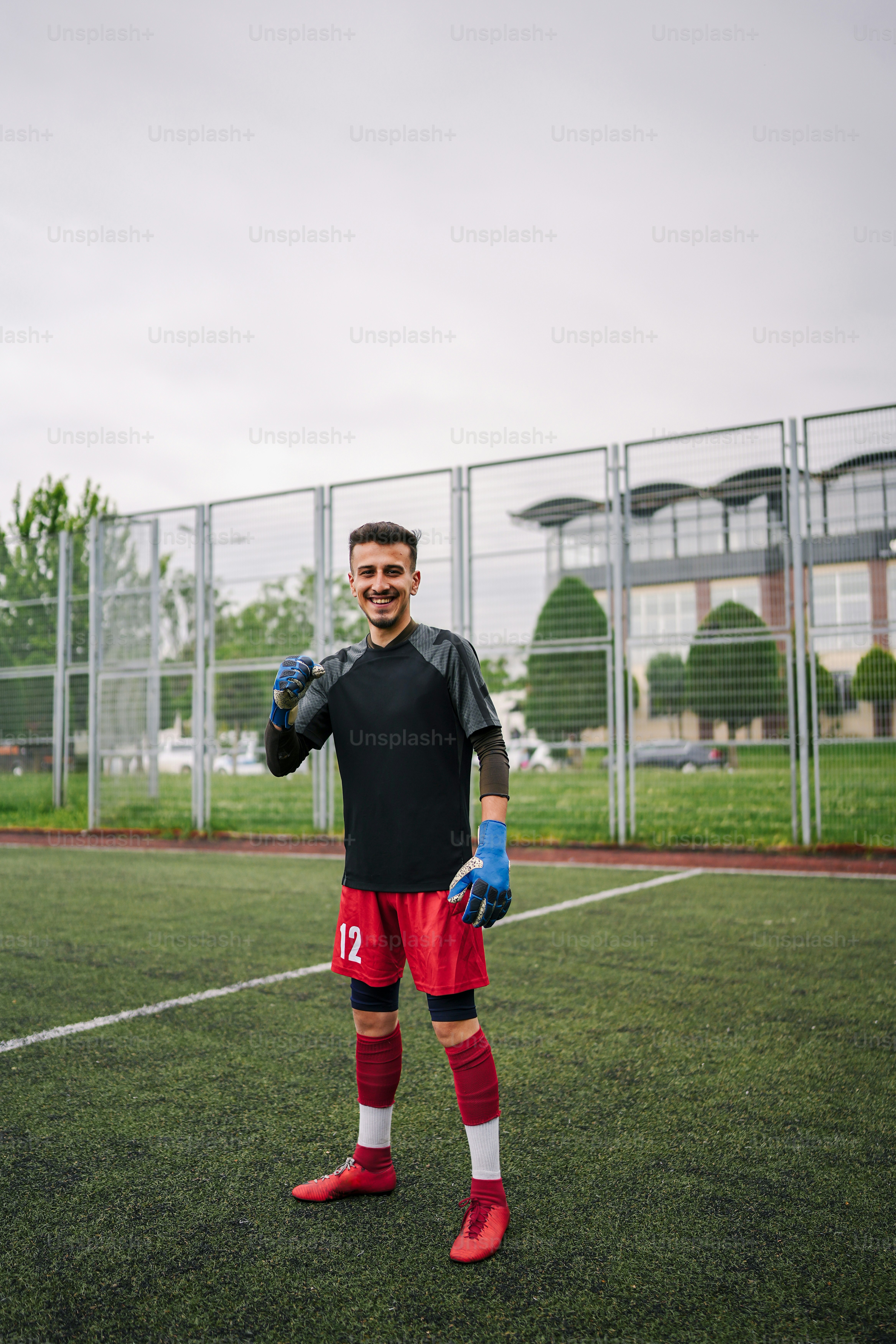 A young man kicking a soccer ball on a field photo – Football Image on ...
