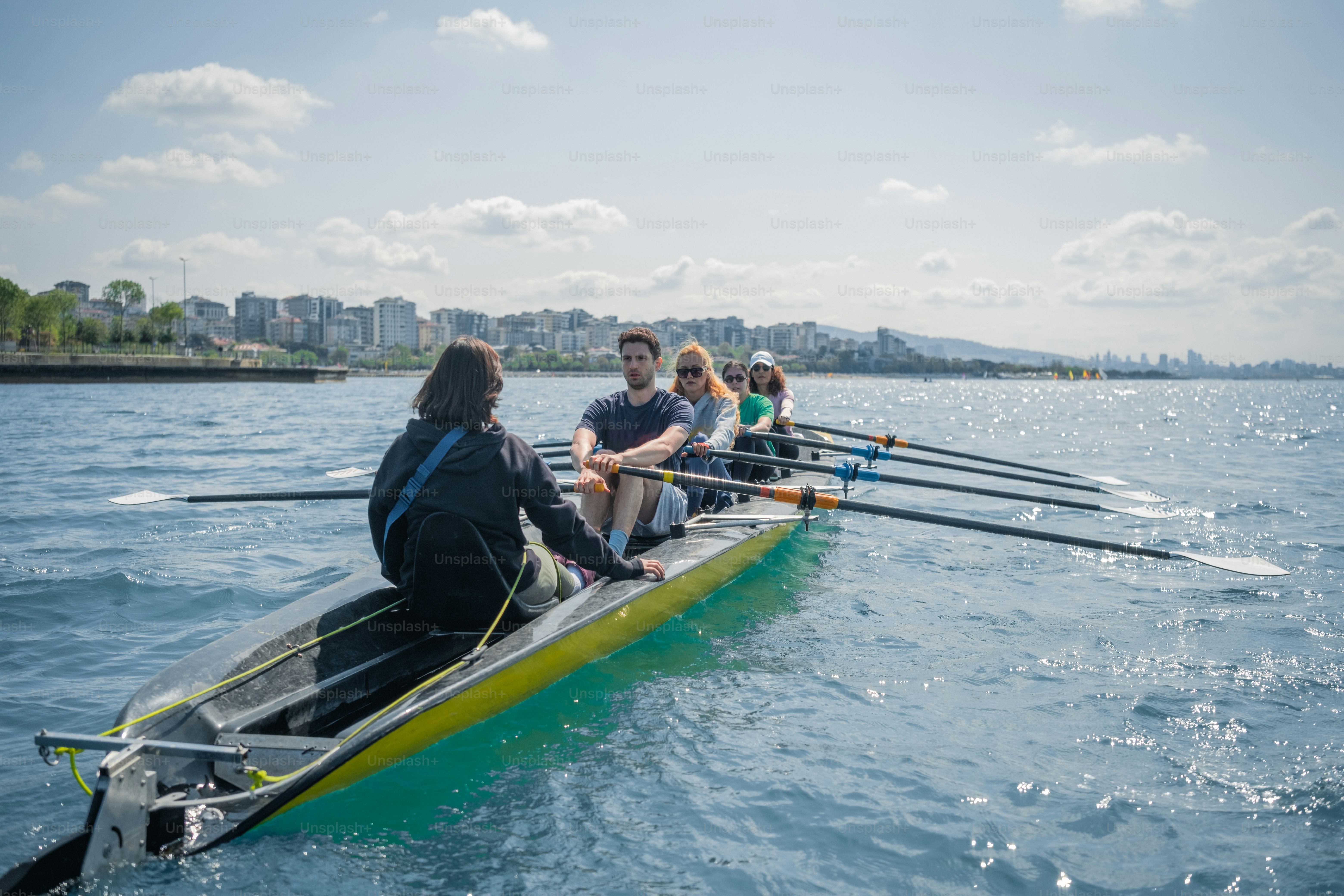 A group of people rowing a boat on a body of water photo – Boat Image ...