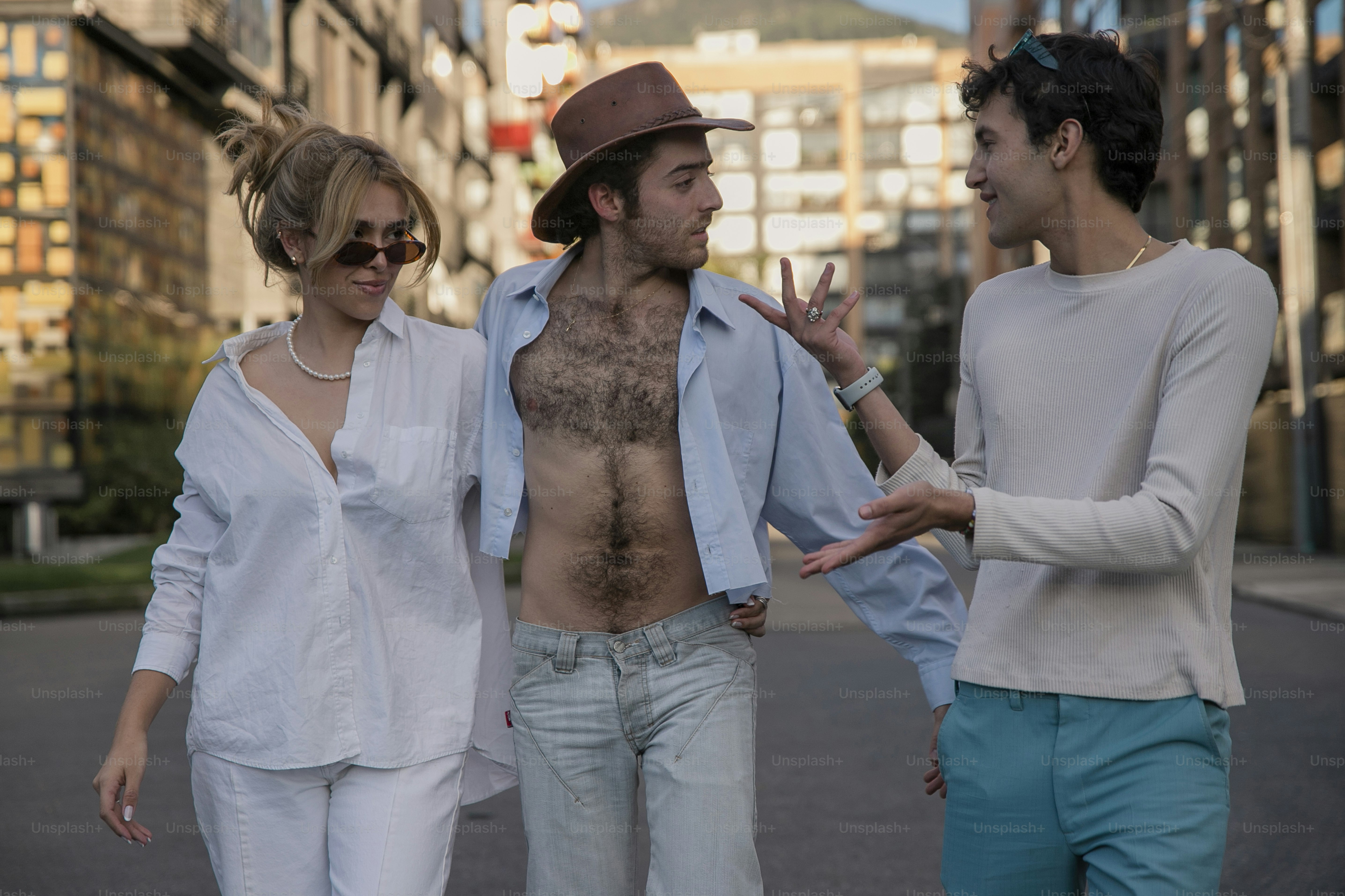 A group of three people walking down a street photo – Community Image ...