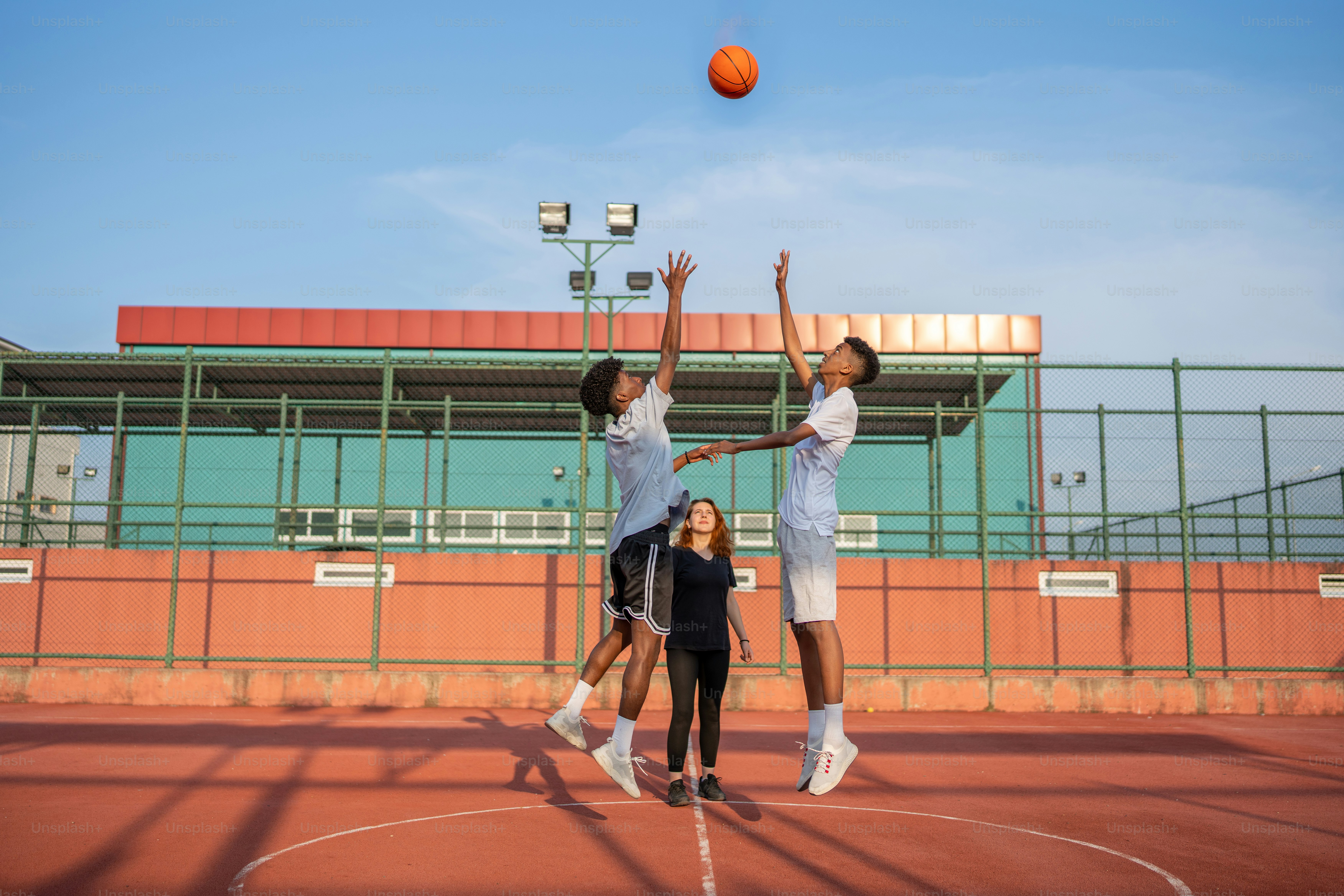 A group of young men playing a game of basketball photo – Outdoor ...