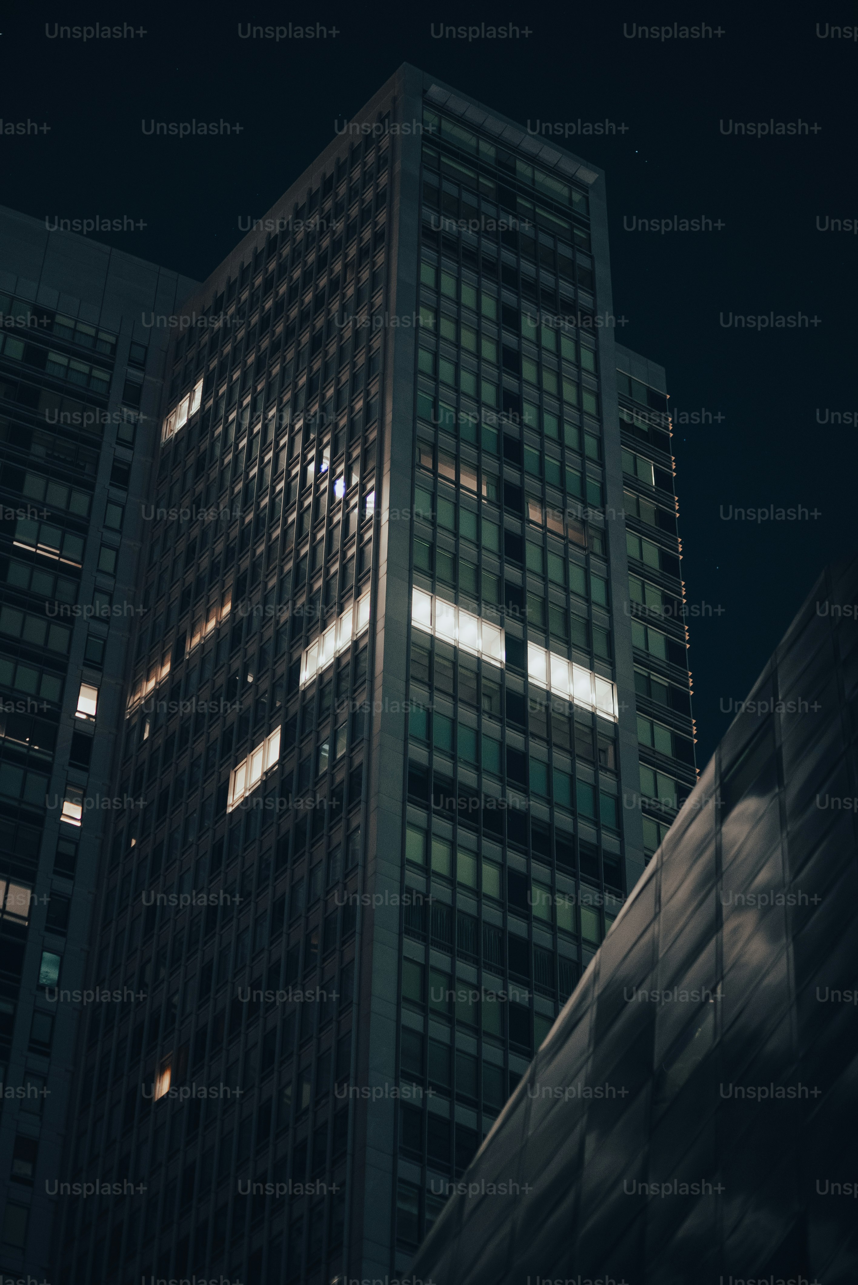 A very tall building lit up at night photo – Wallpaper Image on Unsplash