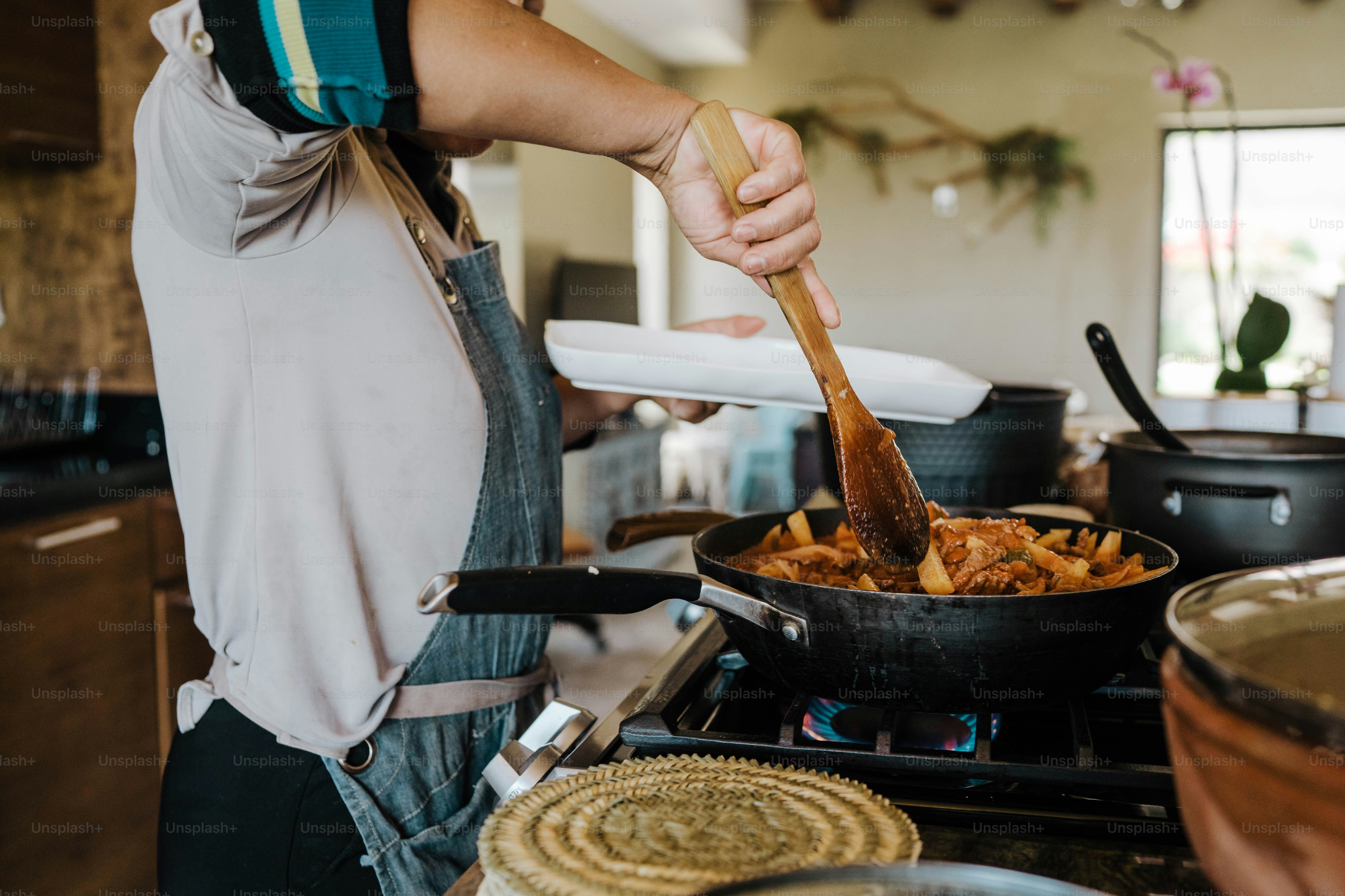 A person cooking food in a pan on the stove photo – Food Image on Unsplash