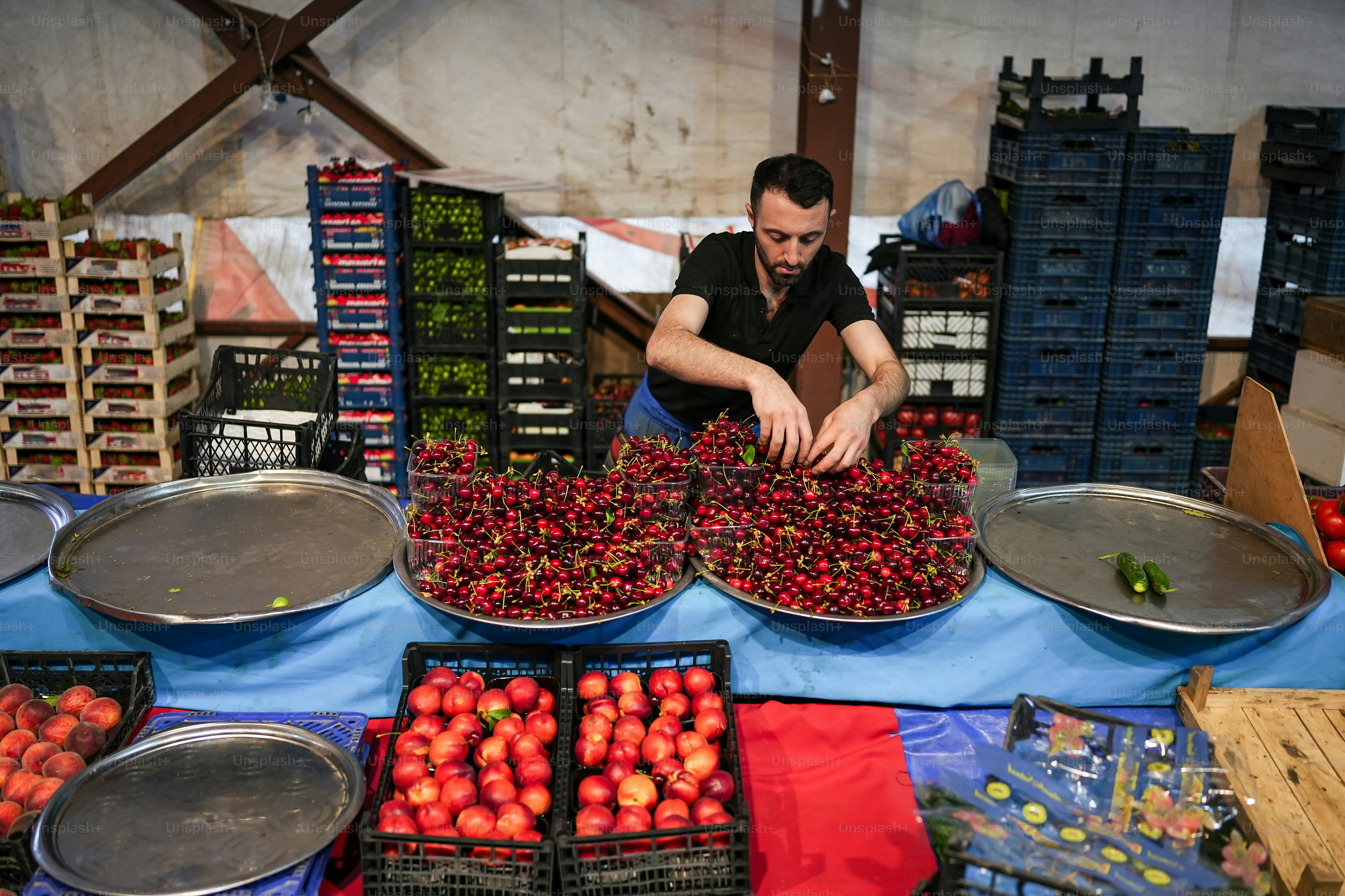 Un hombre parado sobre una mesa llena de mucha fruta foto – Imagen de ...