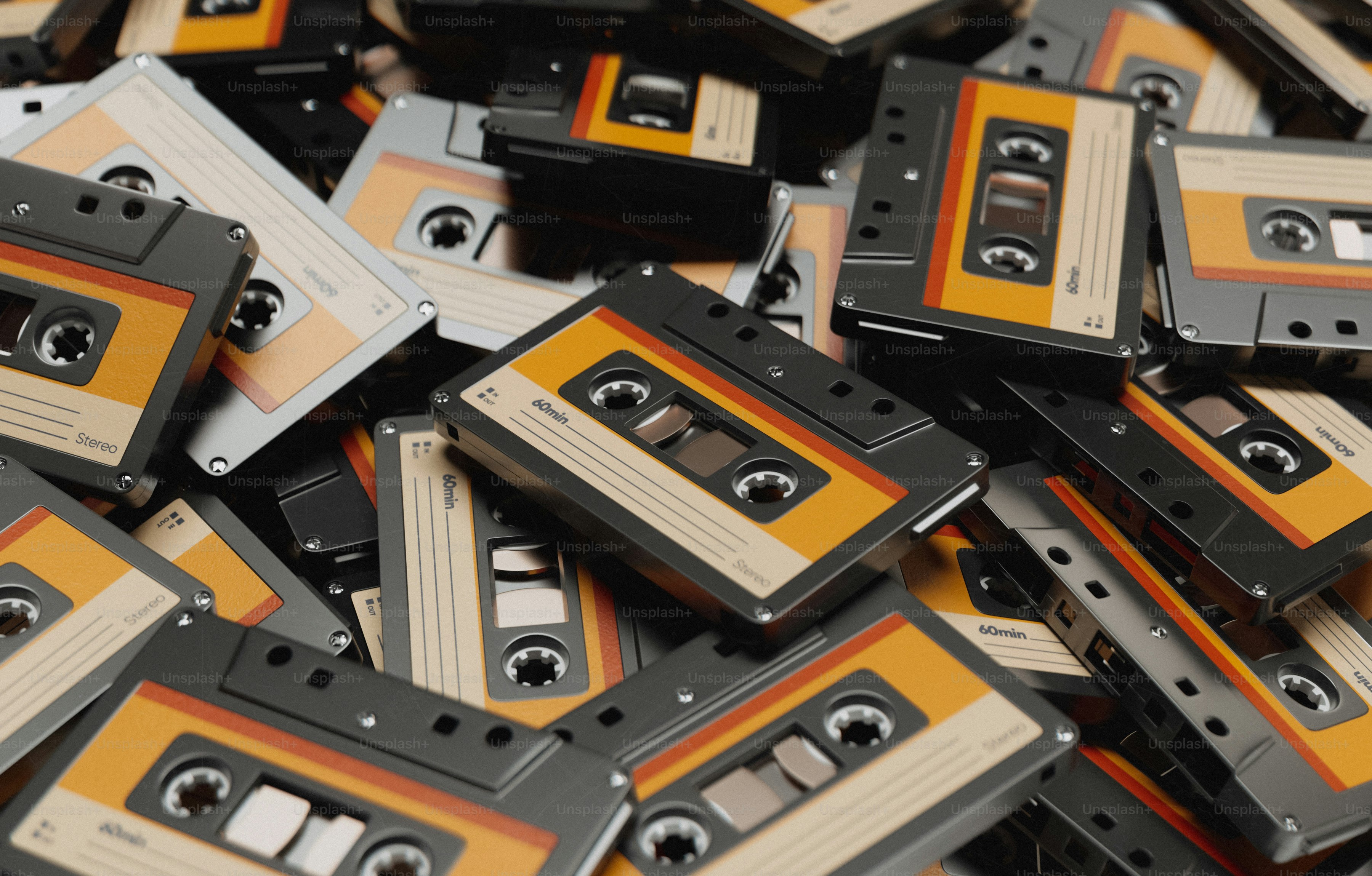 A pile of orange and black cassettes sitting on top of each other photo ...