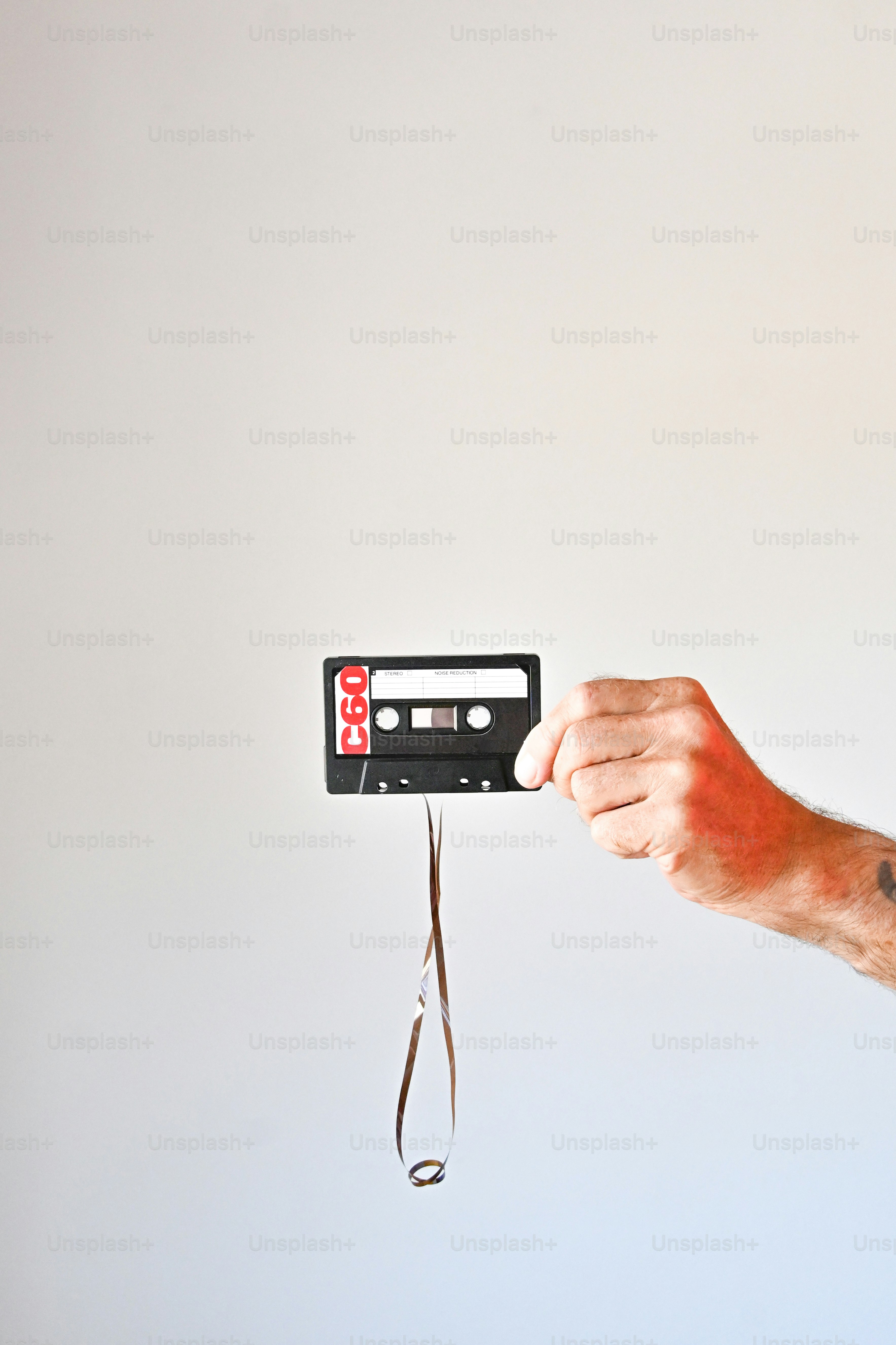 A hand holding a tape recorder with a string attached to it photo ...