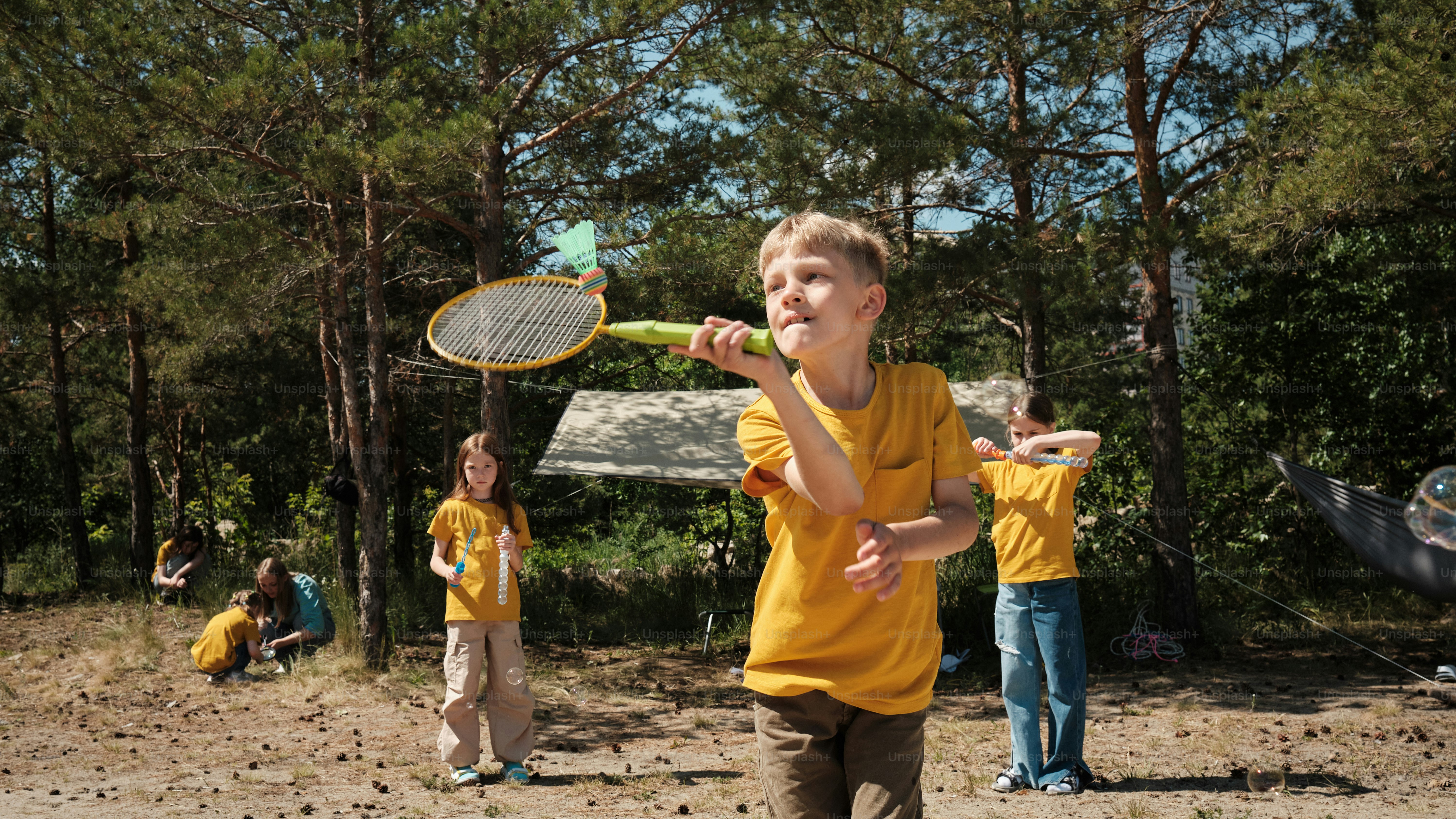 A group of young children playing a game of badminton photo – Adventure ...