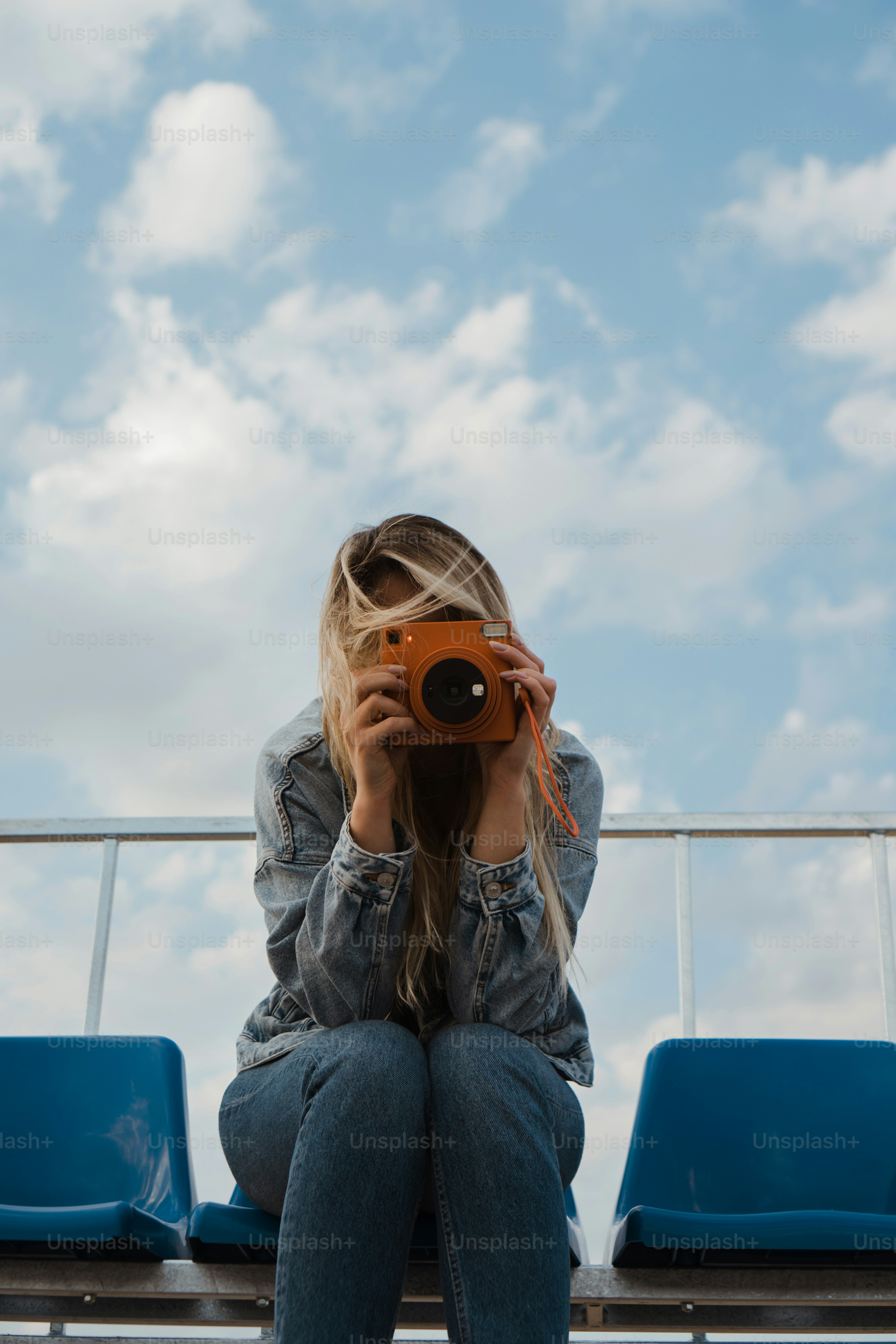 A woman sitting on a bench holding a camera photo – Instant photo Image ...