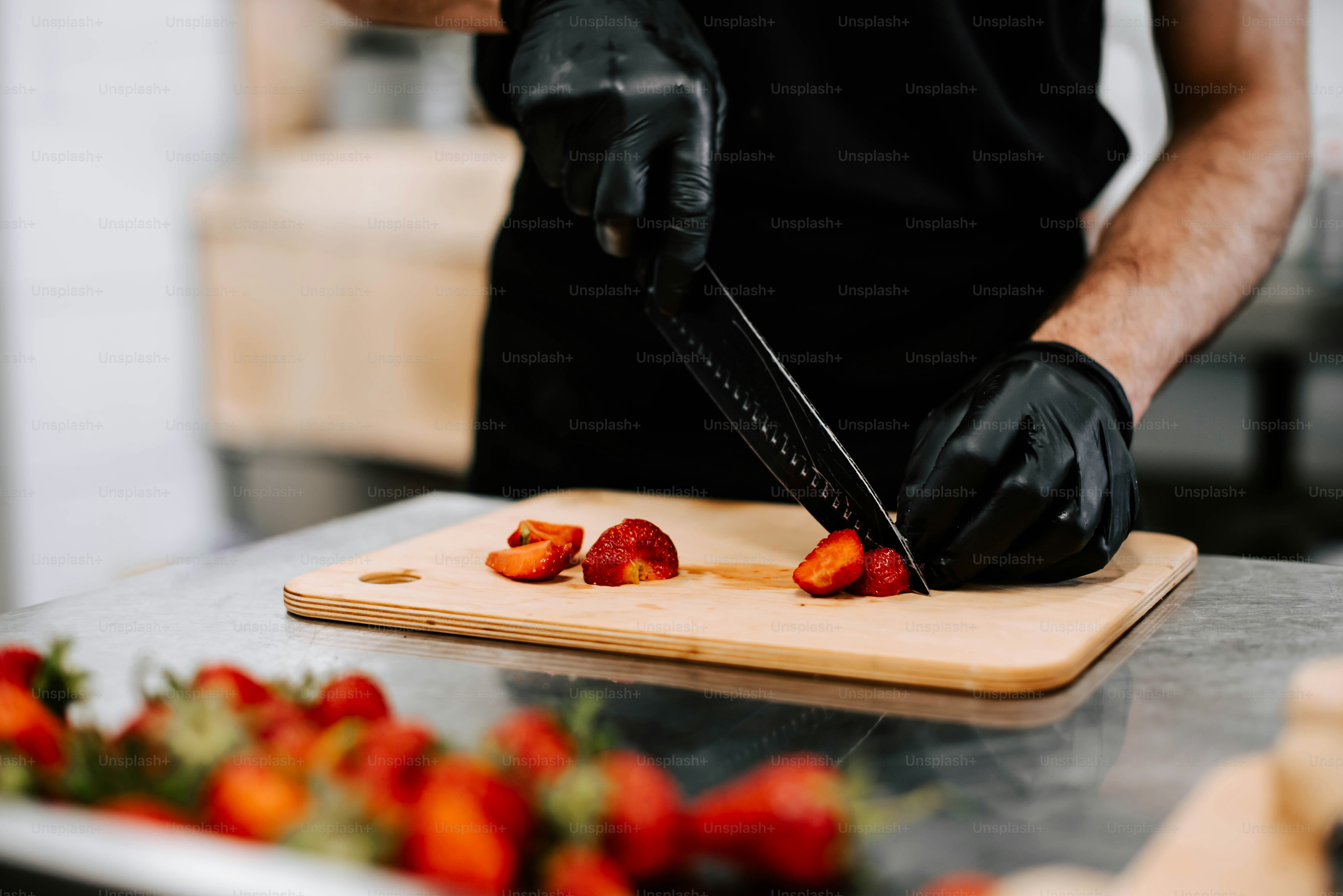 Una persona cortando fresas en una tabla de cortar foto – Imagen de ...