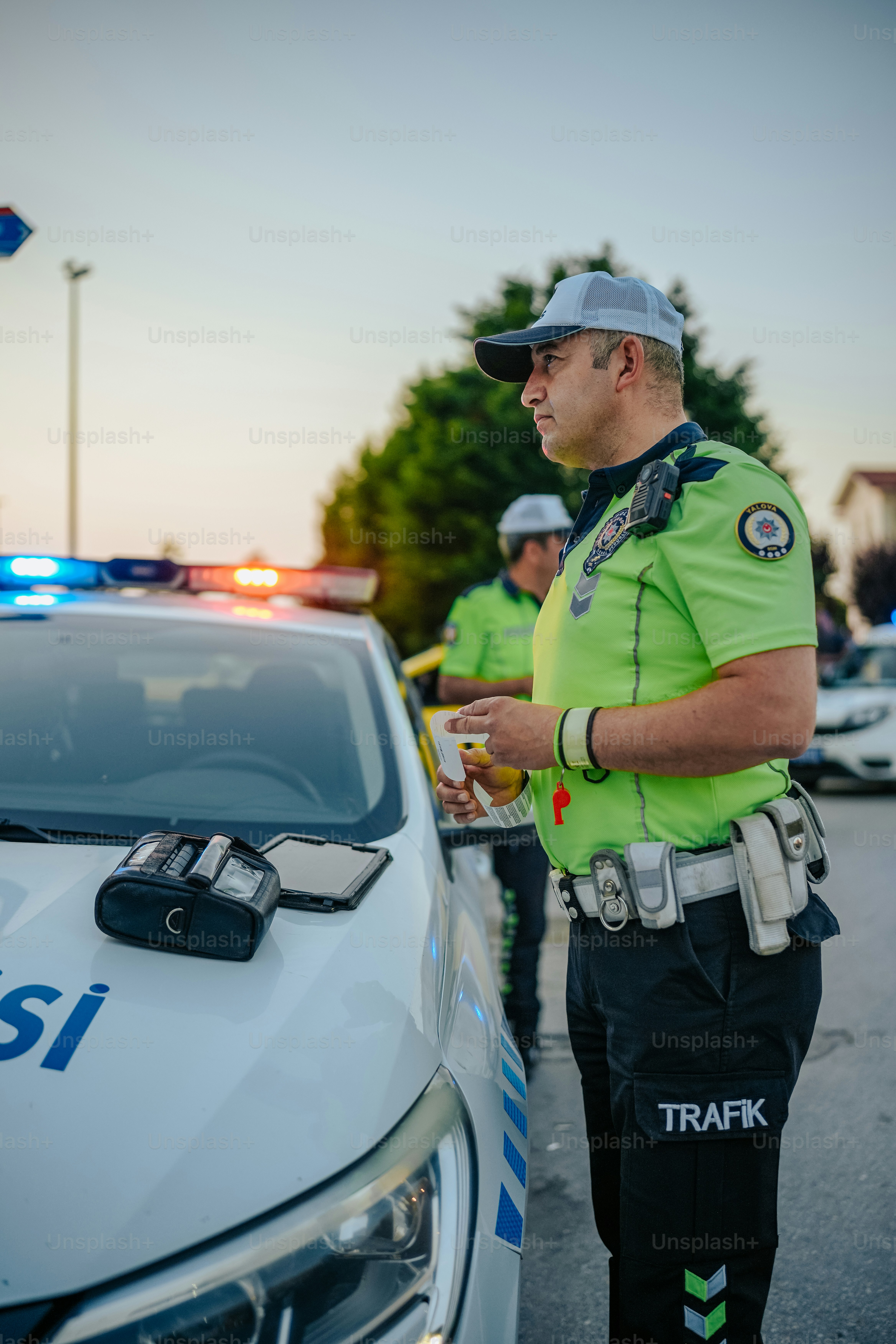 A police officer standing next to a police car photo – Police officer ...
