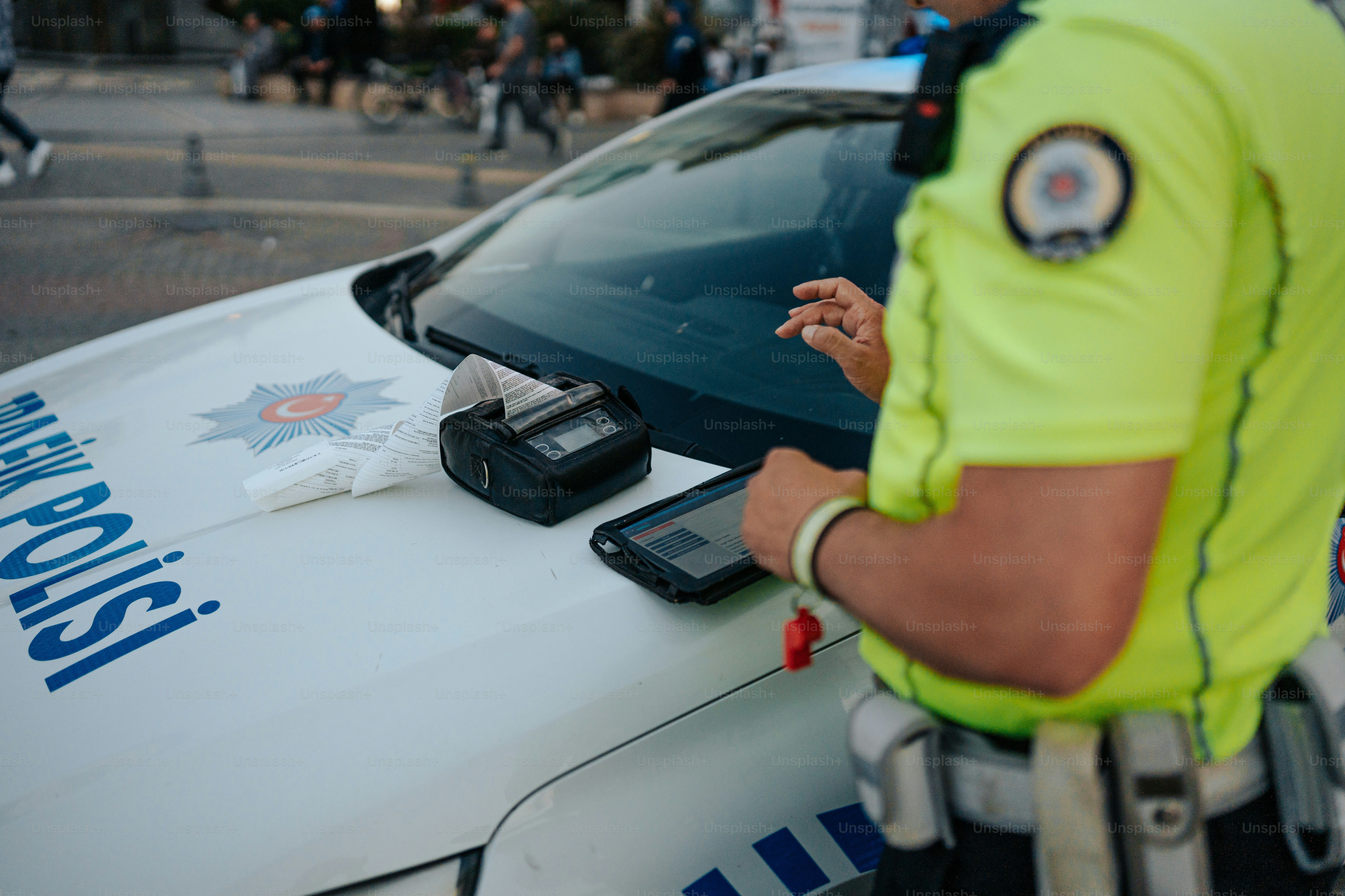 A police officer standing next to a police car photo – Police car Image ...