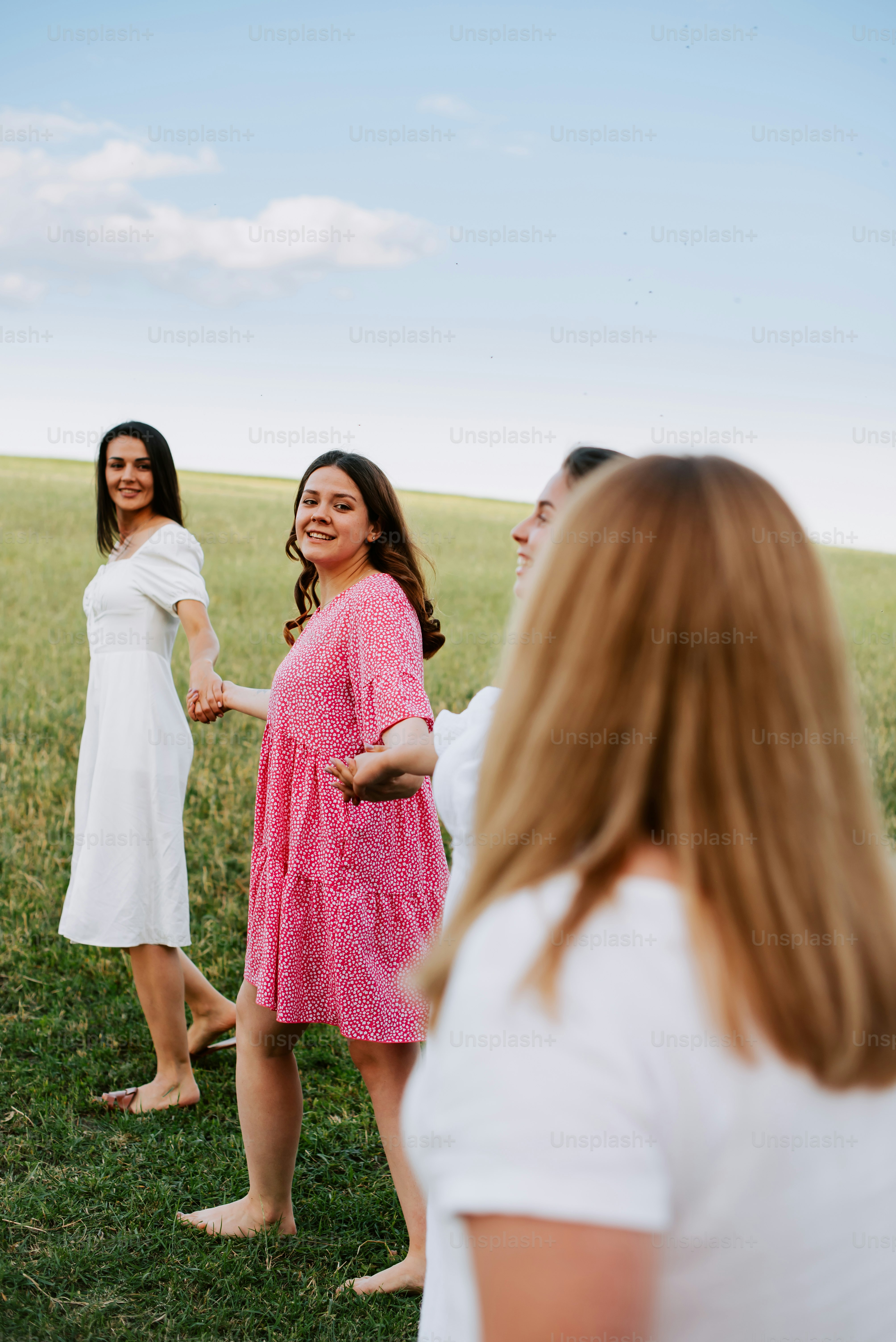A group of three women walking across a lush green field photo – Party ...