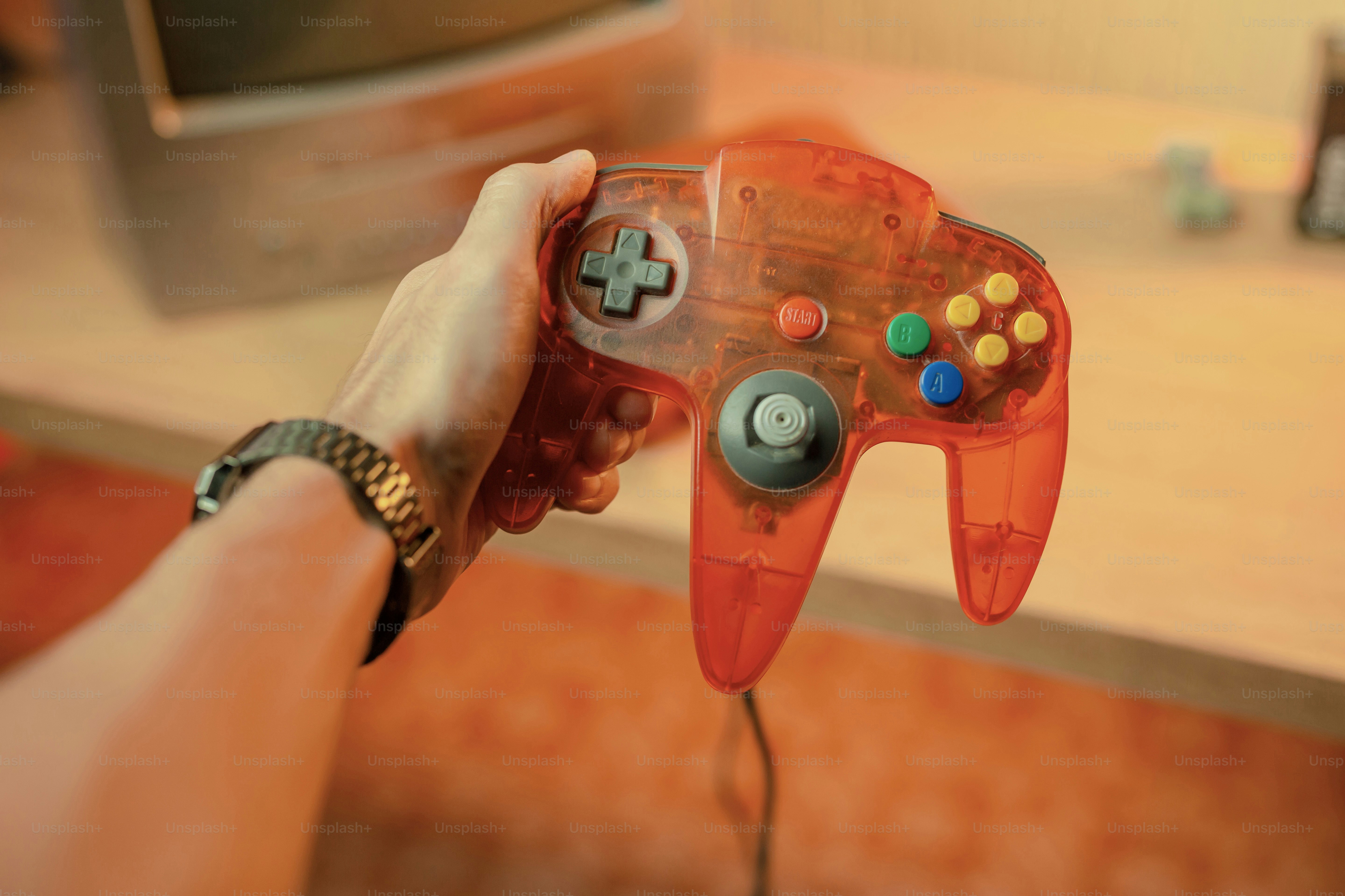 A close up of a person holding a video game controller photo – 90s ...
