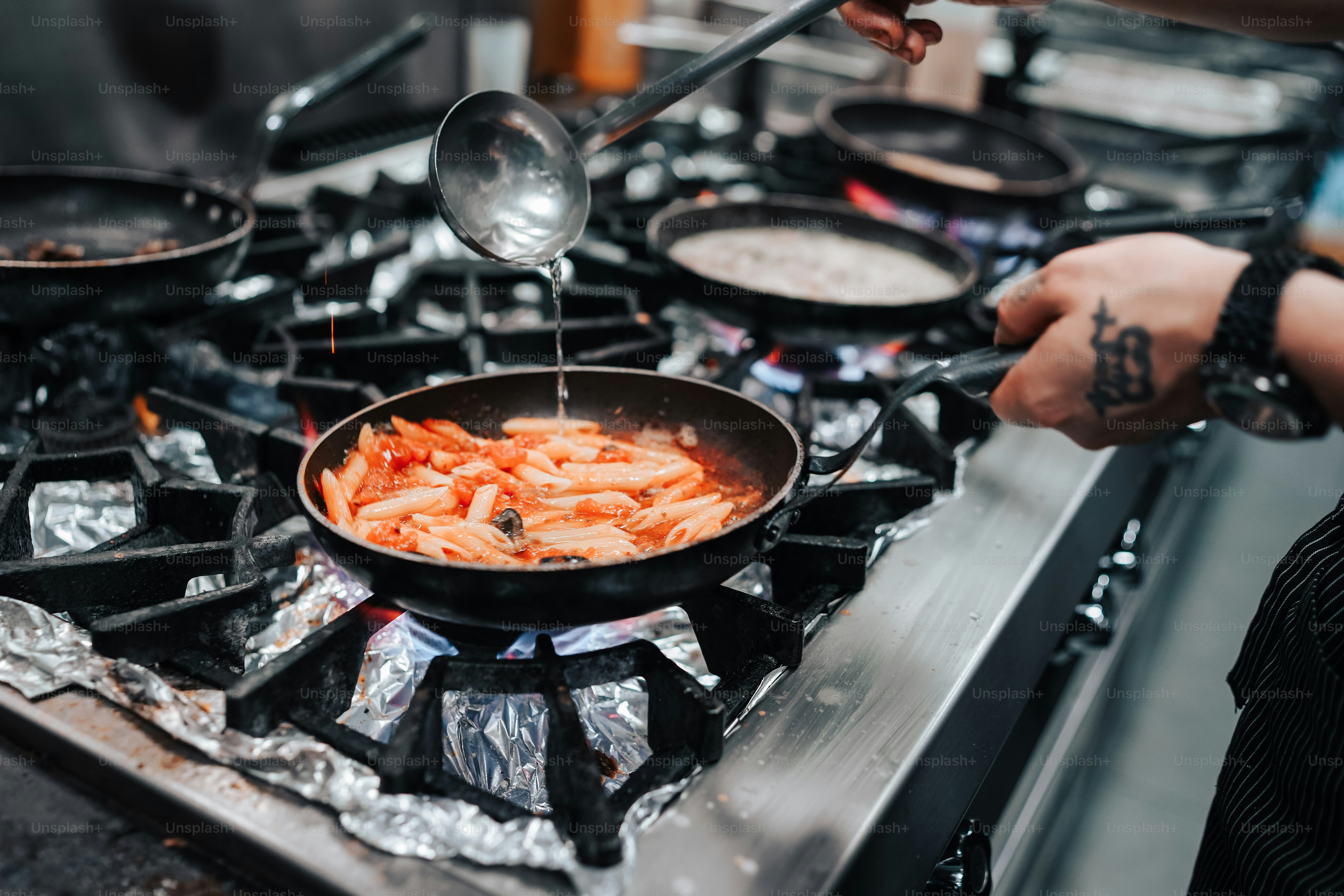 A woman cooking food on top of a stove photo – Kitchen Image on Unsplash