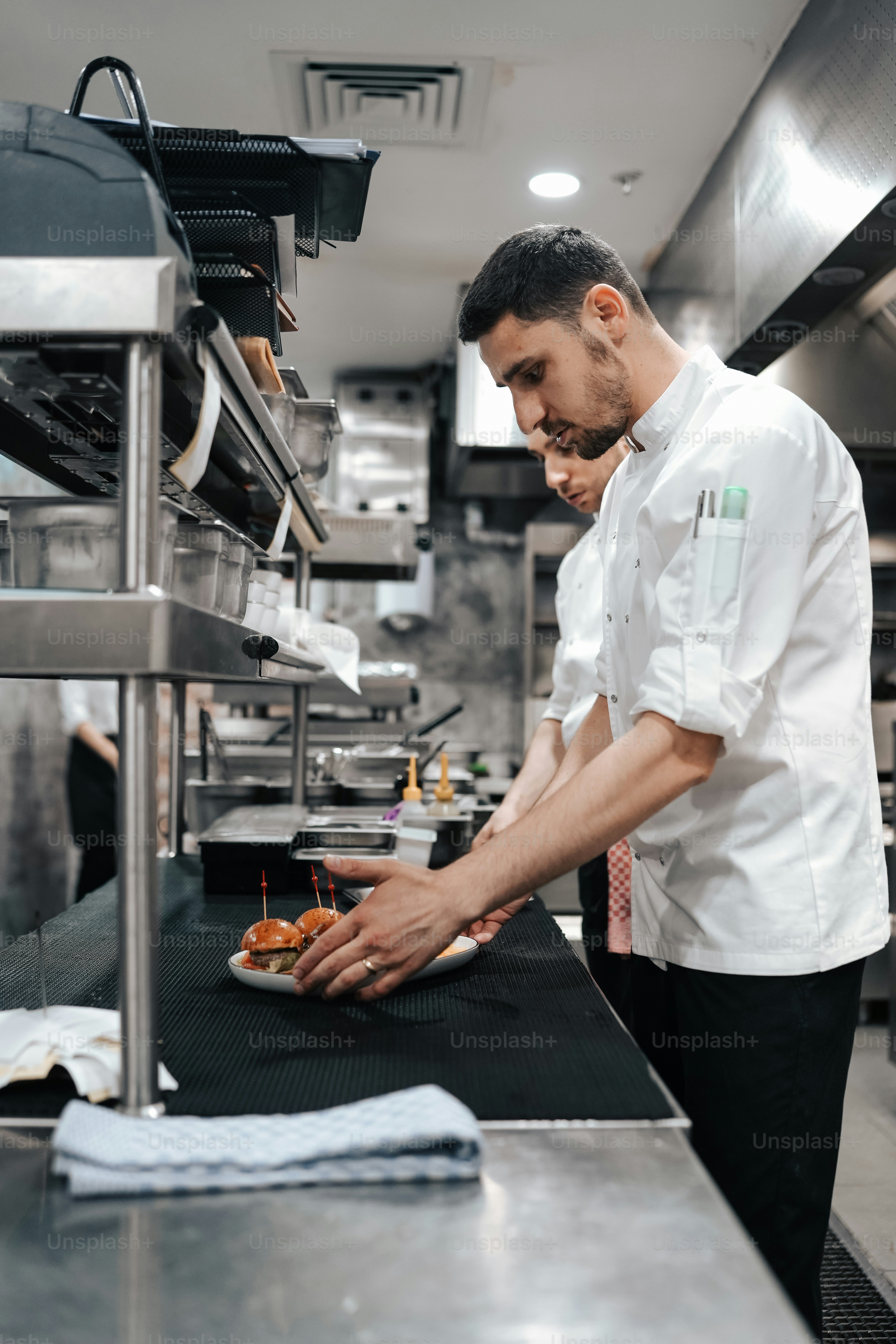 A man in a kitchen preparing food on top of a stove photo – Kitchen ...
