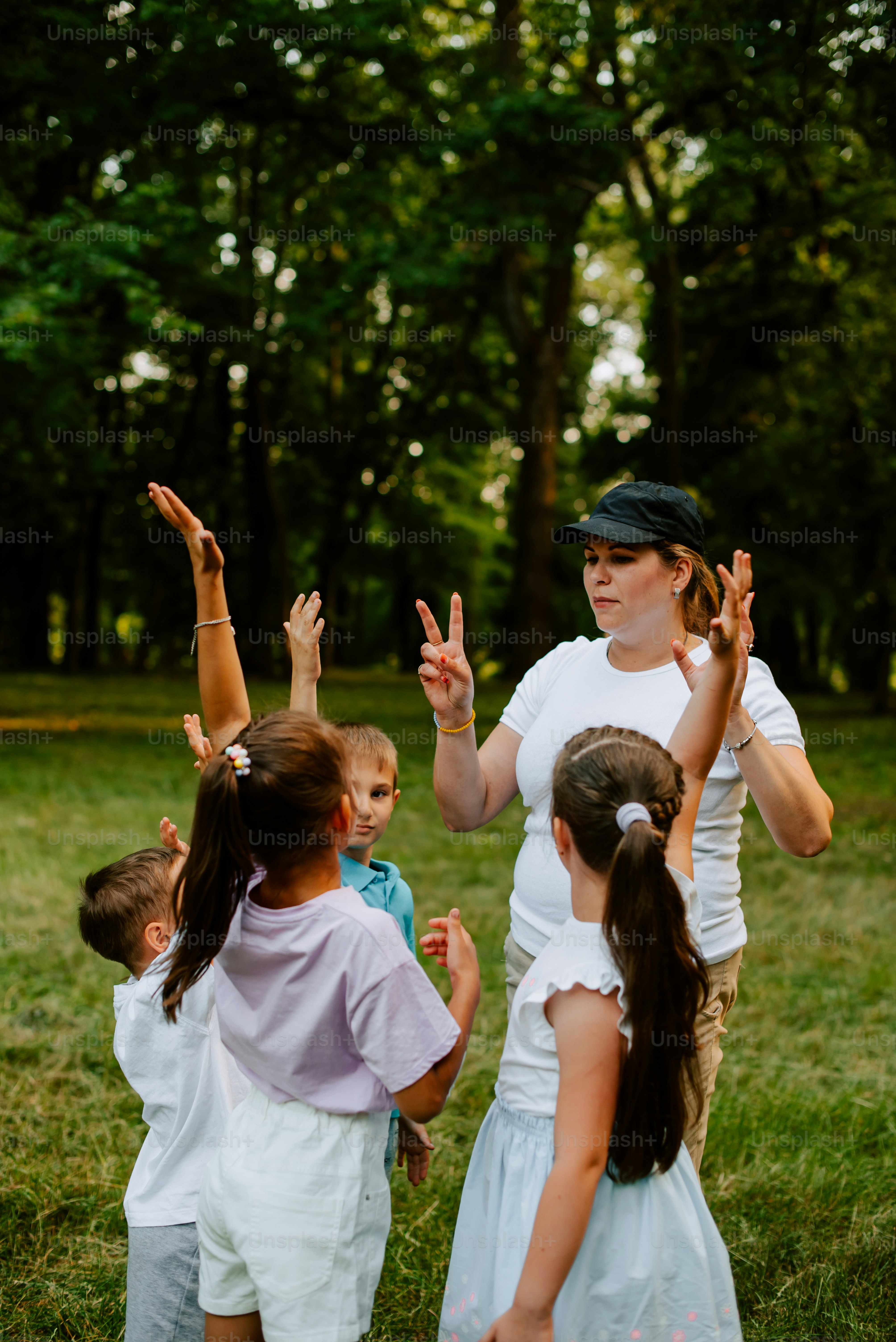 A group of children standing around a woman photo – Summer camp Image ...