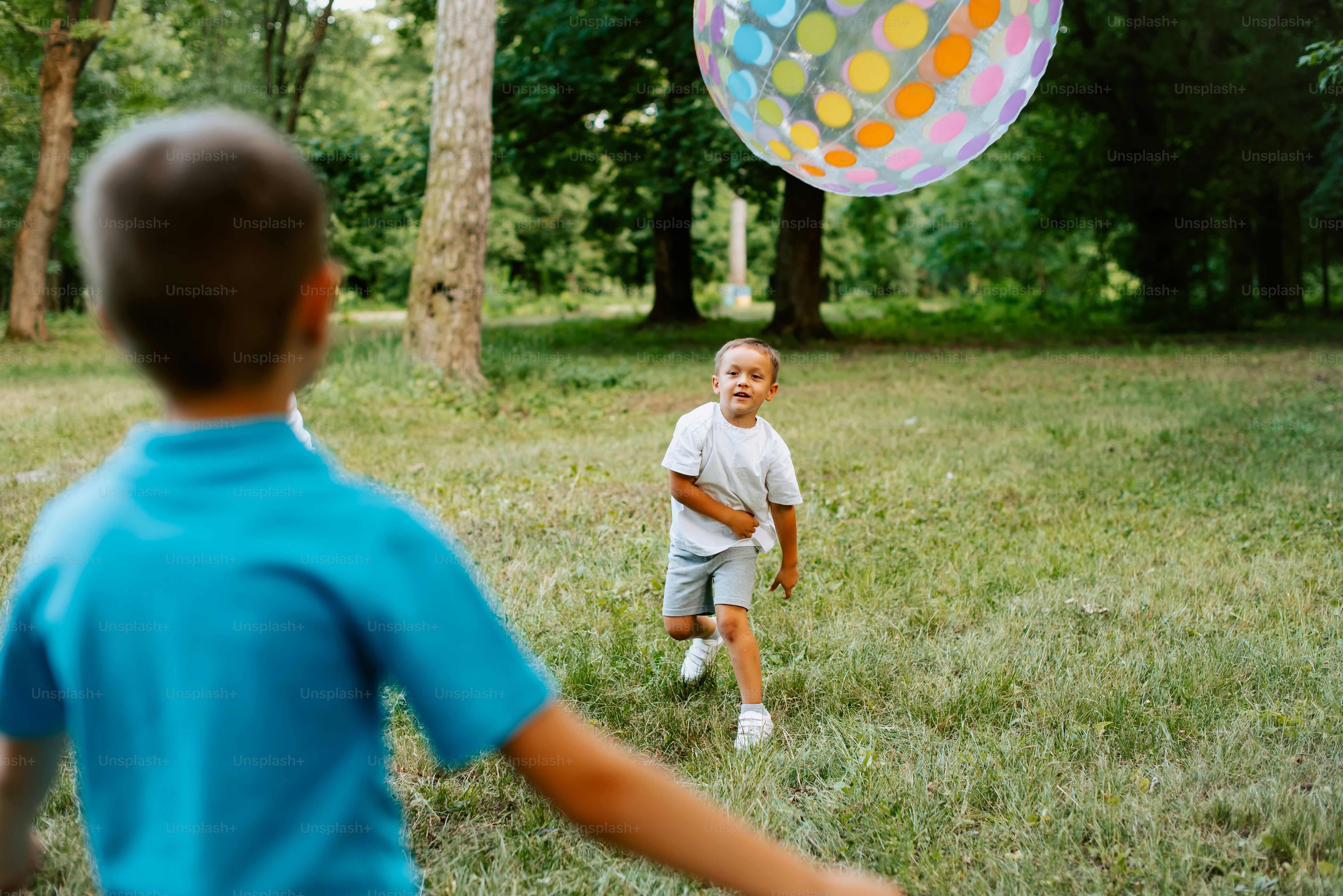 Foto Un niño está jugando con una pelota en el parque – Campamento de ...