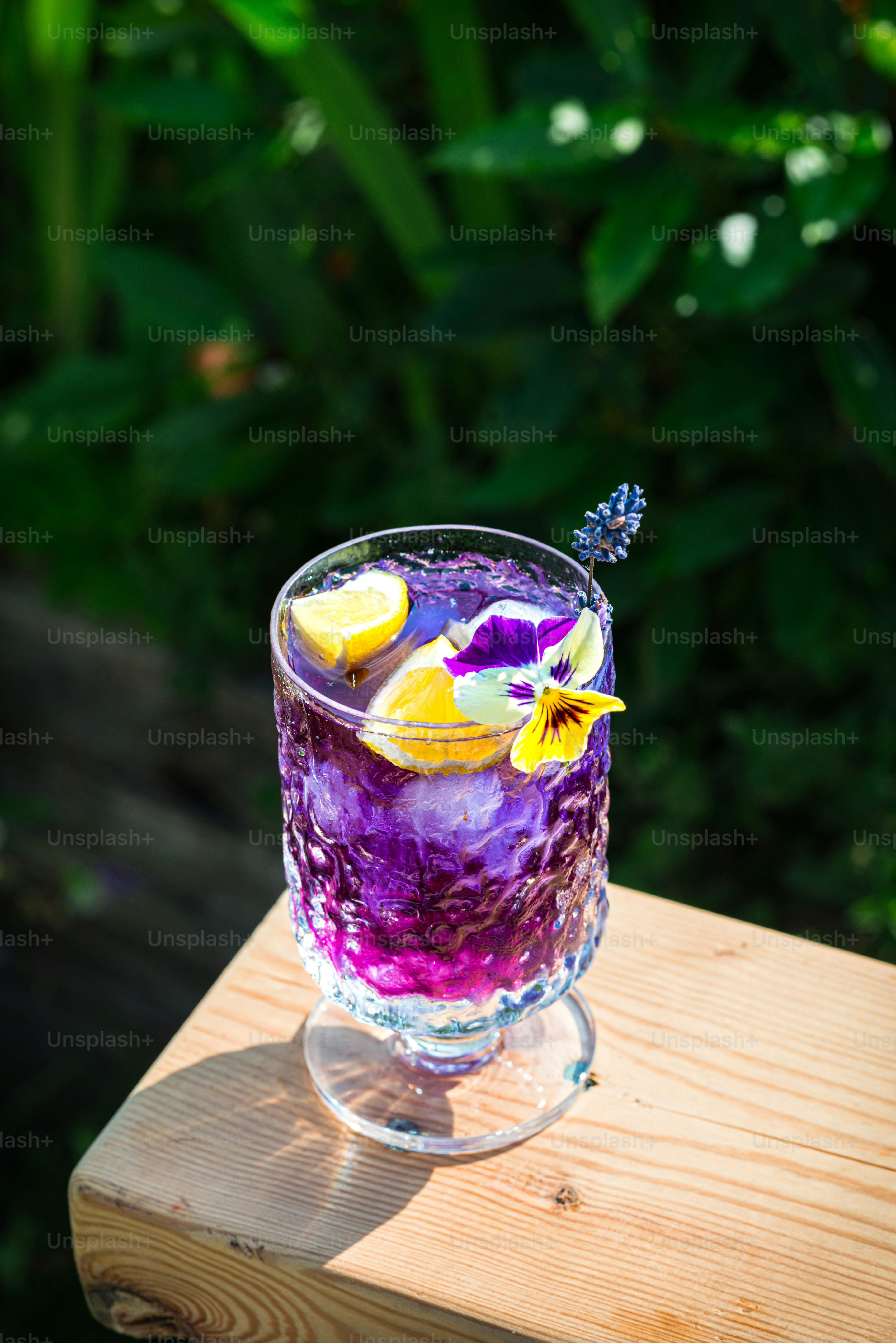 Foto Una bebida morada con limones y arándanos en un vaso – Beber con ...
