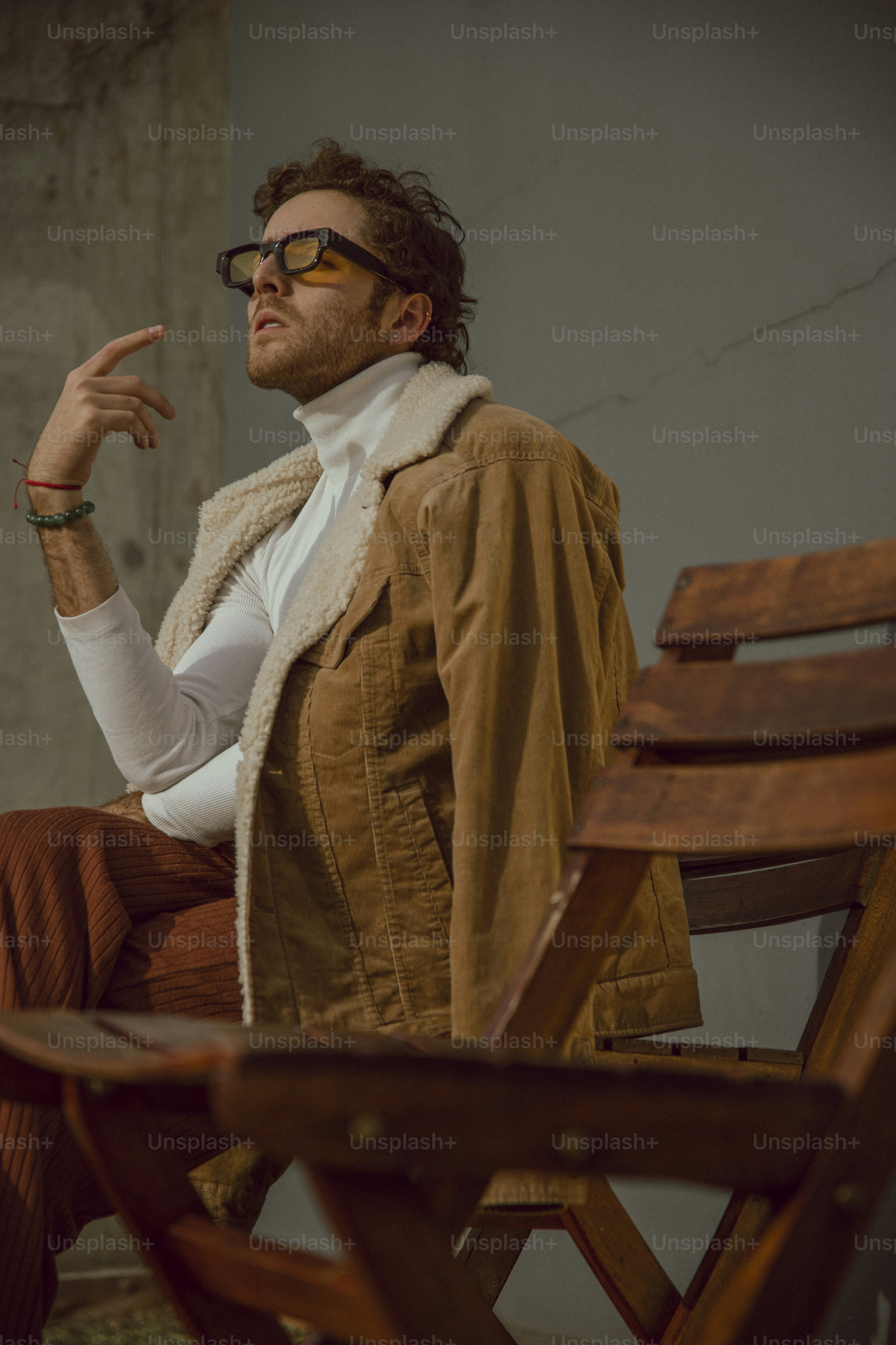 A man sitting in a chair smoking a cigarette photo – Gen z Image on ...