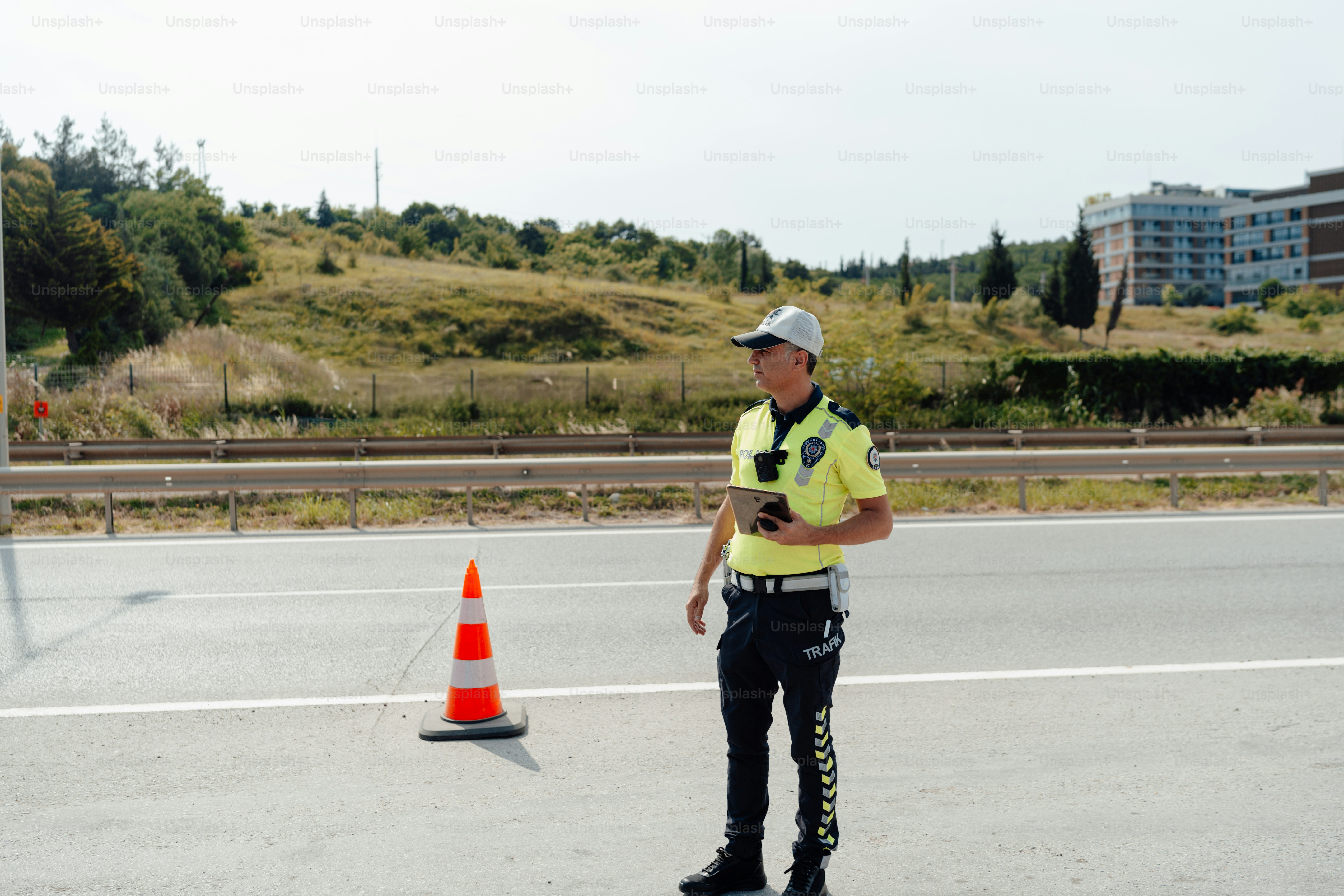 A police officer standing next to a traffic cone photo – Traffic police ...