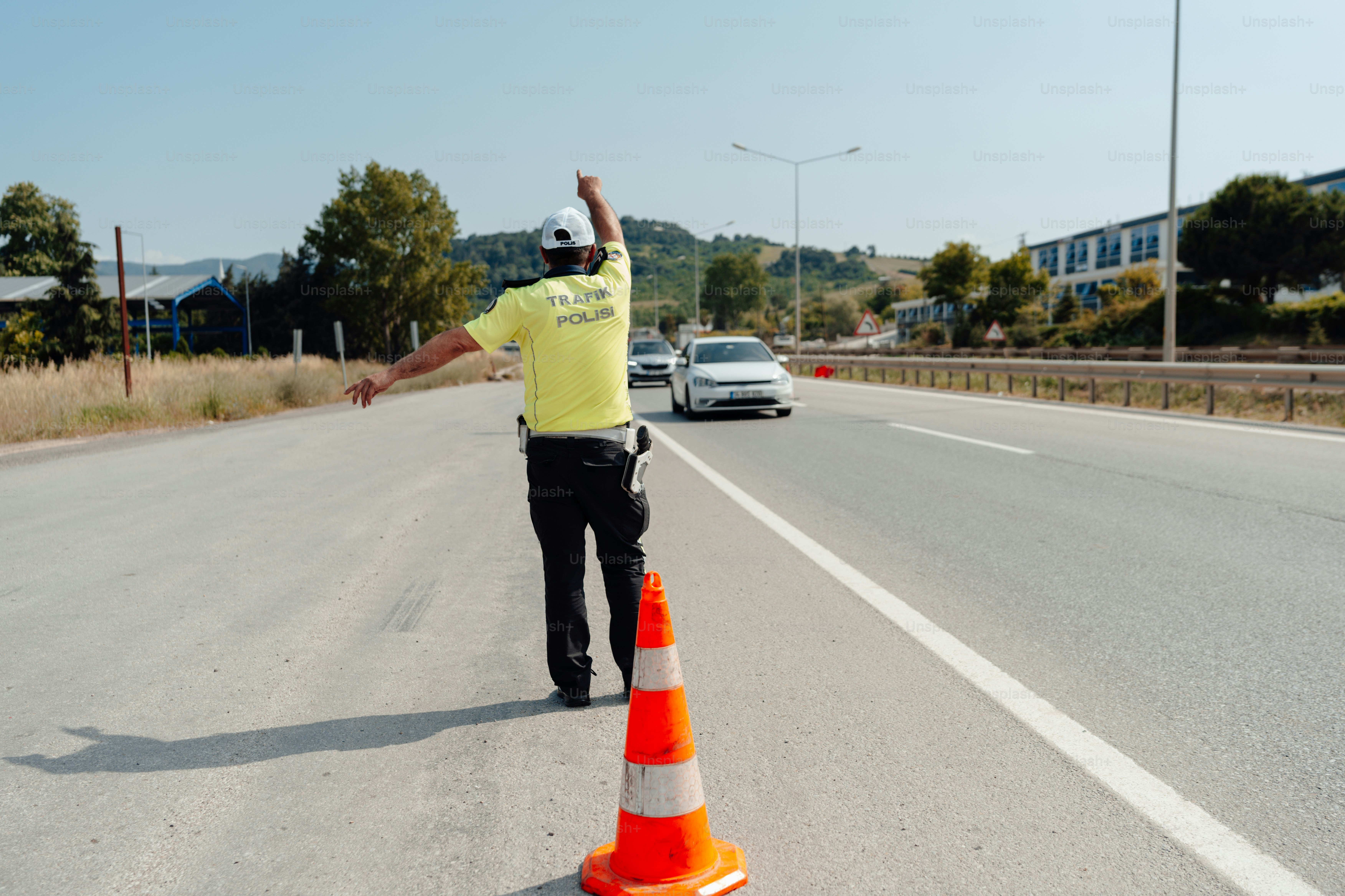 A police officer directing traffic on a highway photo – Transportation ...