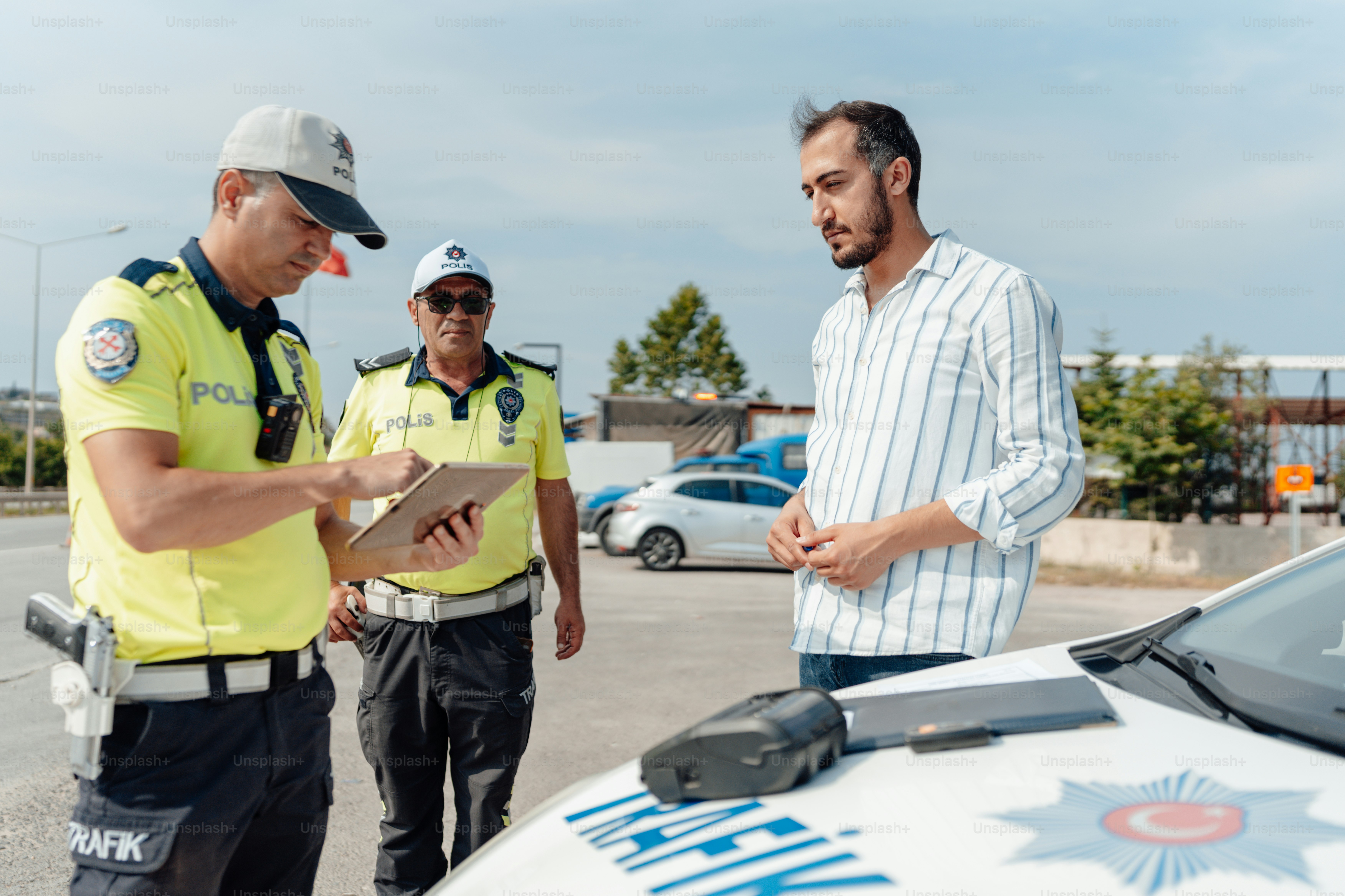 Two police officers standing next to a police car photo – Police Image ...