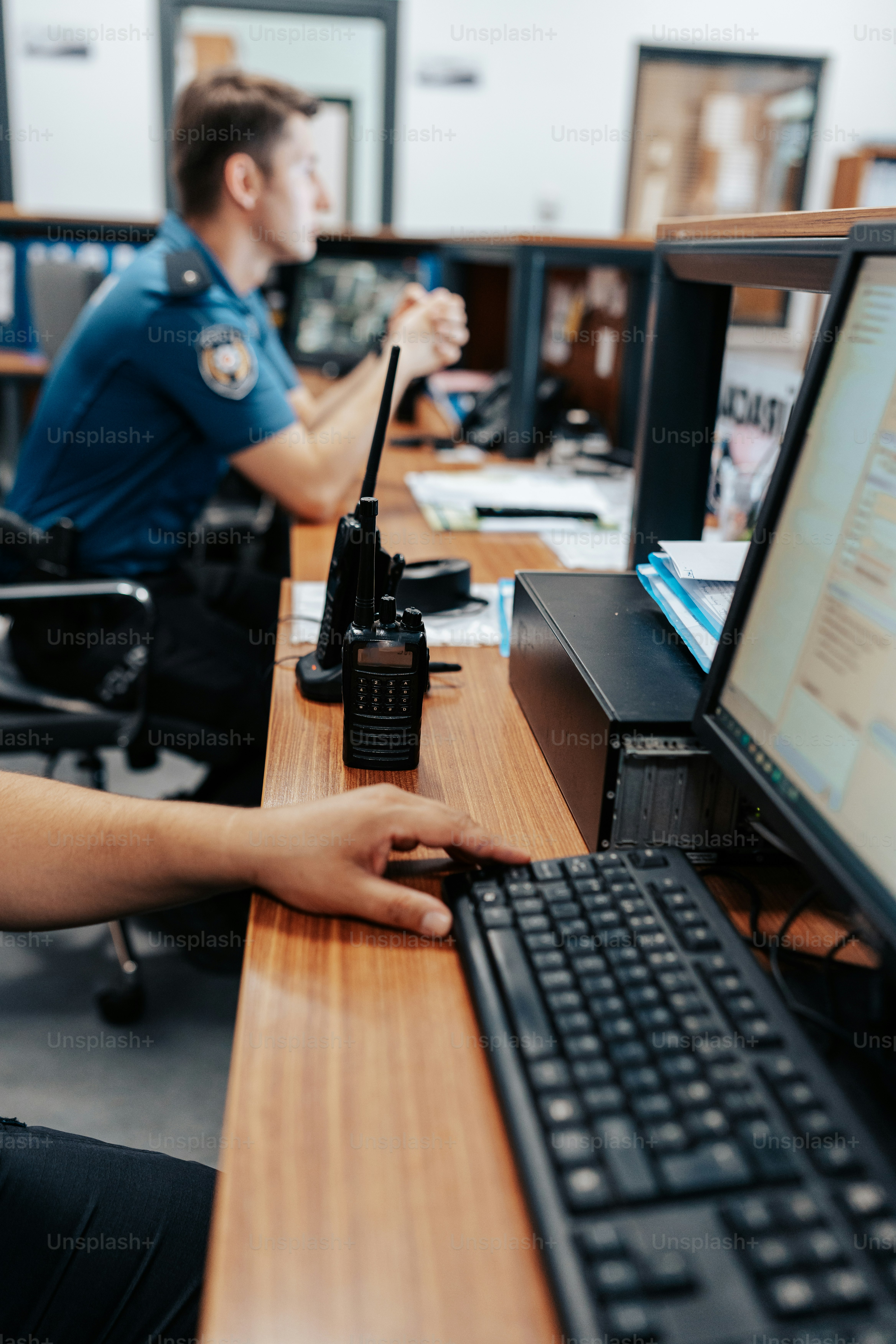 A man sitting at a desk with a laptop computer photo – Police officer ...