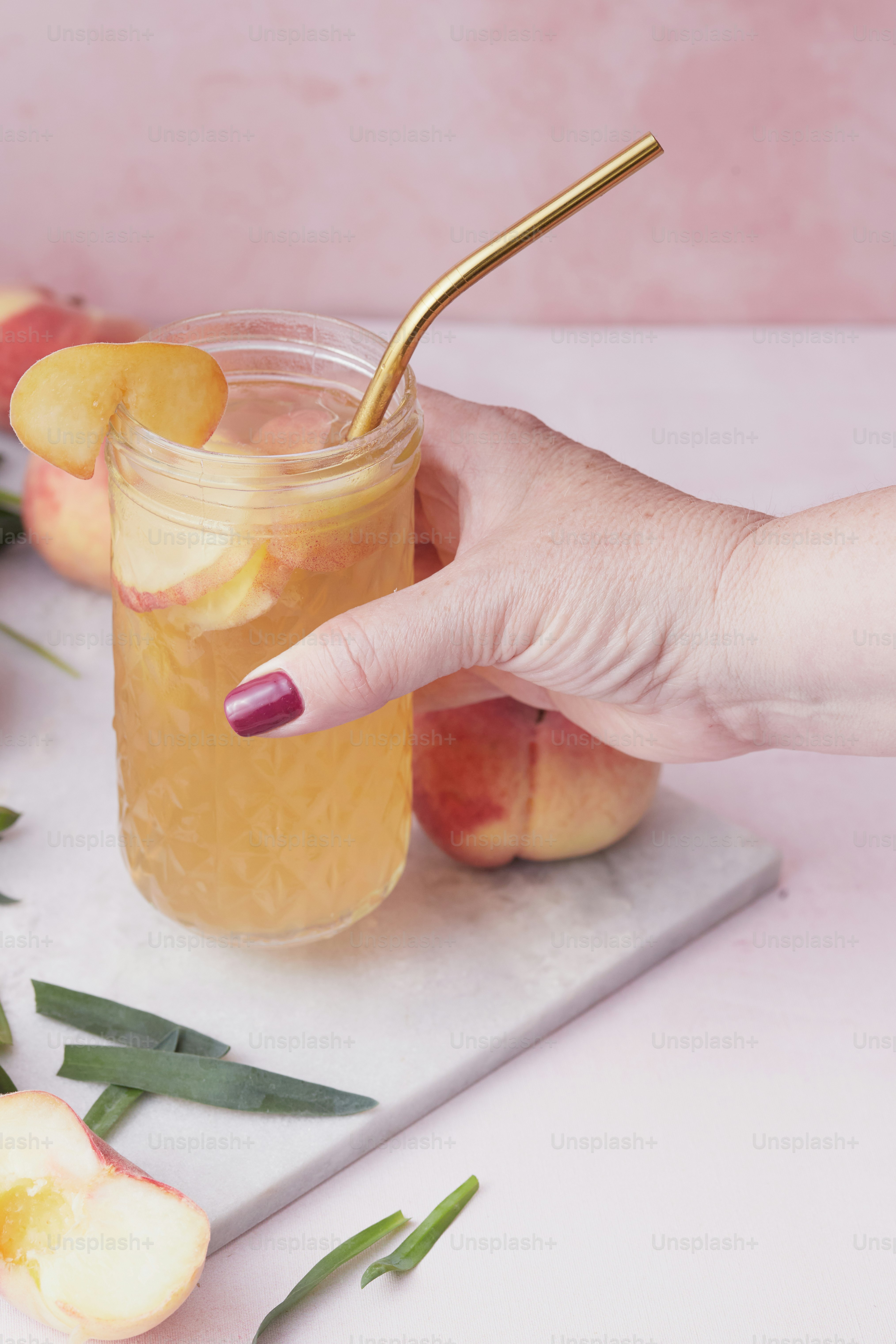 A hand holding a straw over a jar of apple cider photo – Peaches Image ...