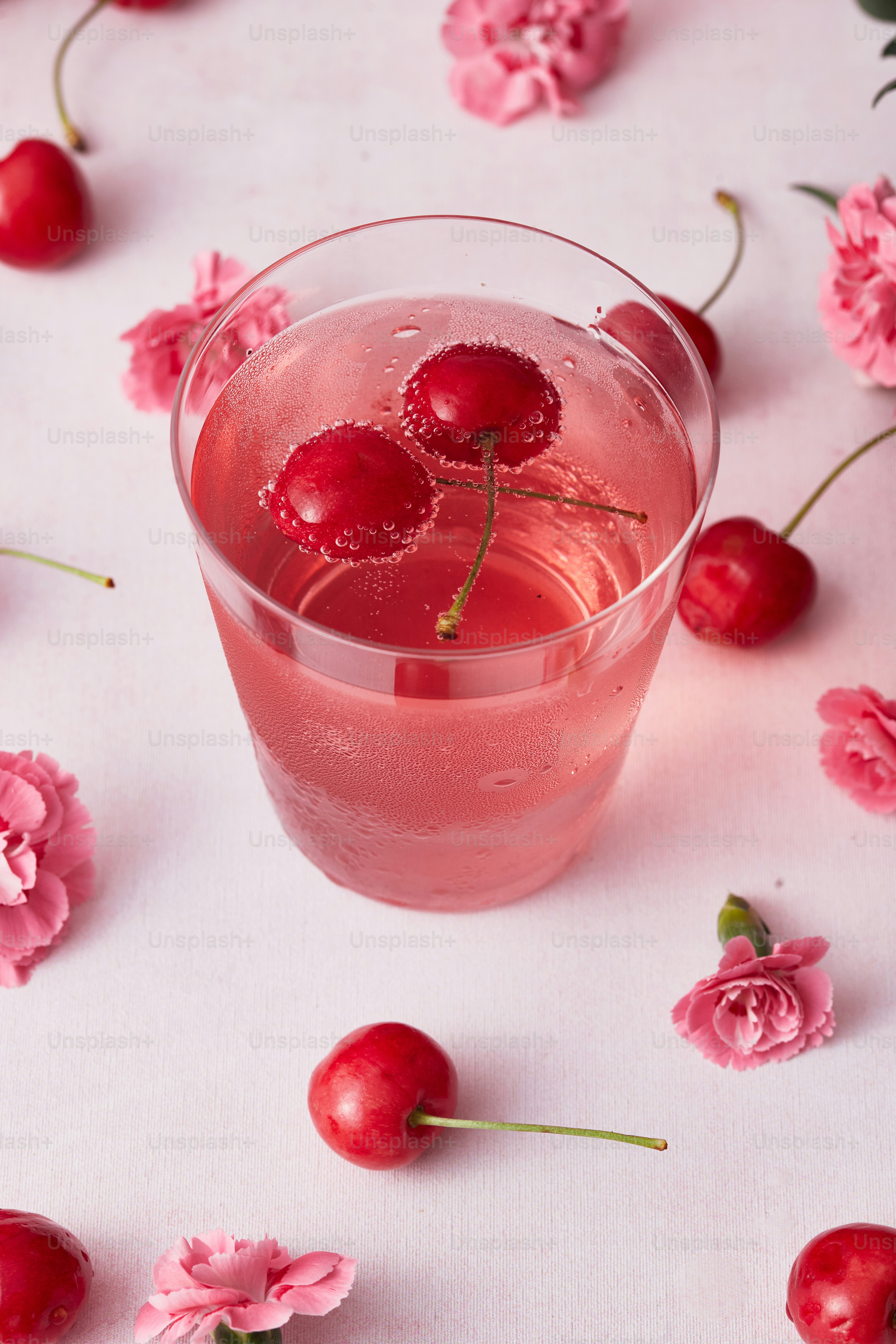 A pink drink with cherries on a table photo – Canned drink Image on ...