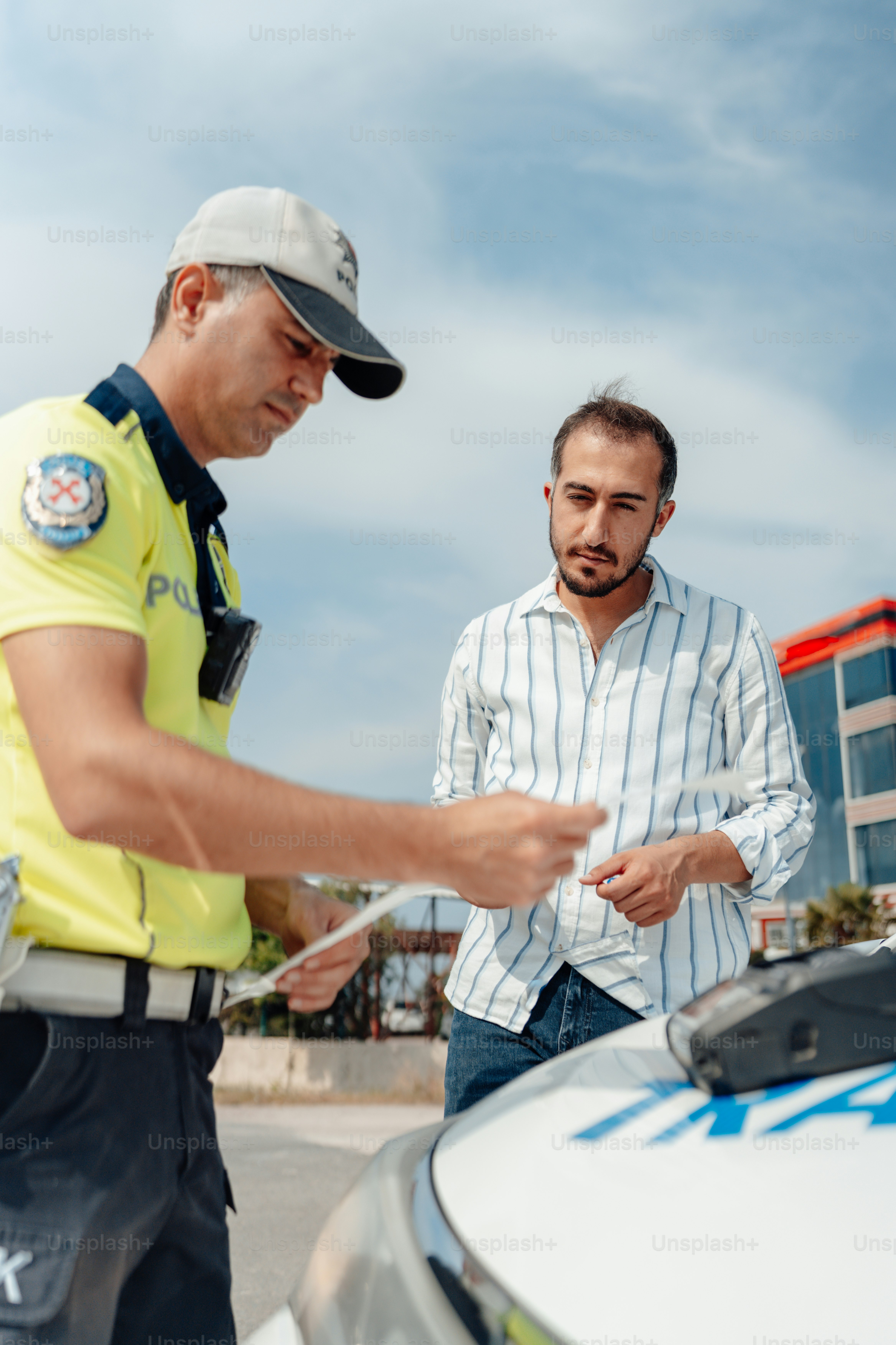 A police officer standing next to a police car photo – Police Image on ...