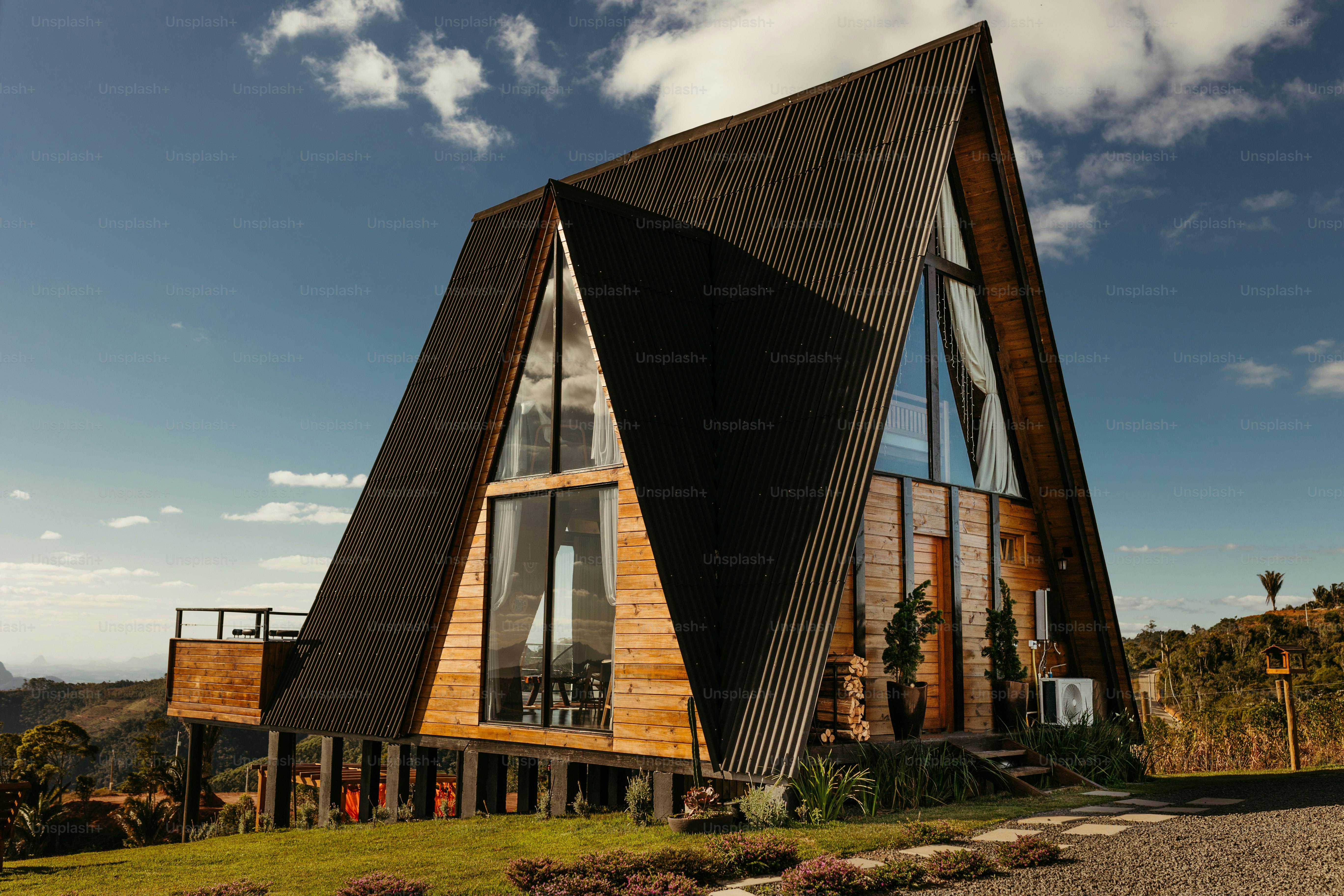 A large triangular shaped building with windows on top of it photo ...