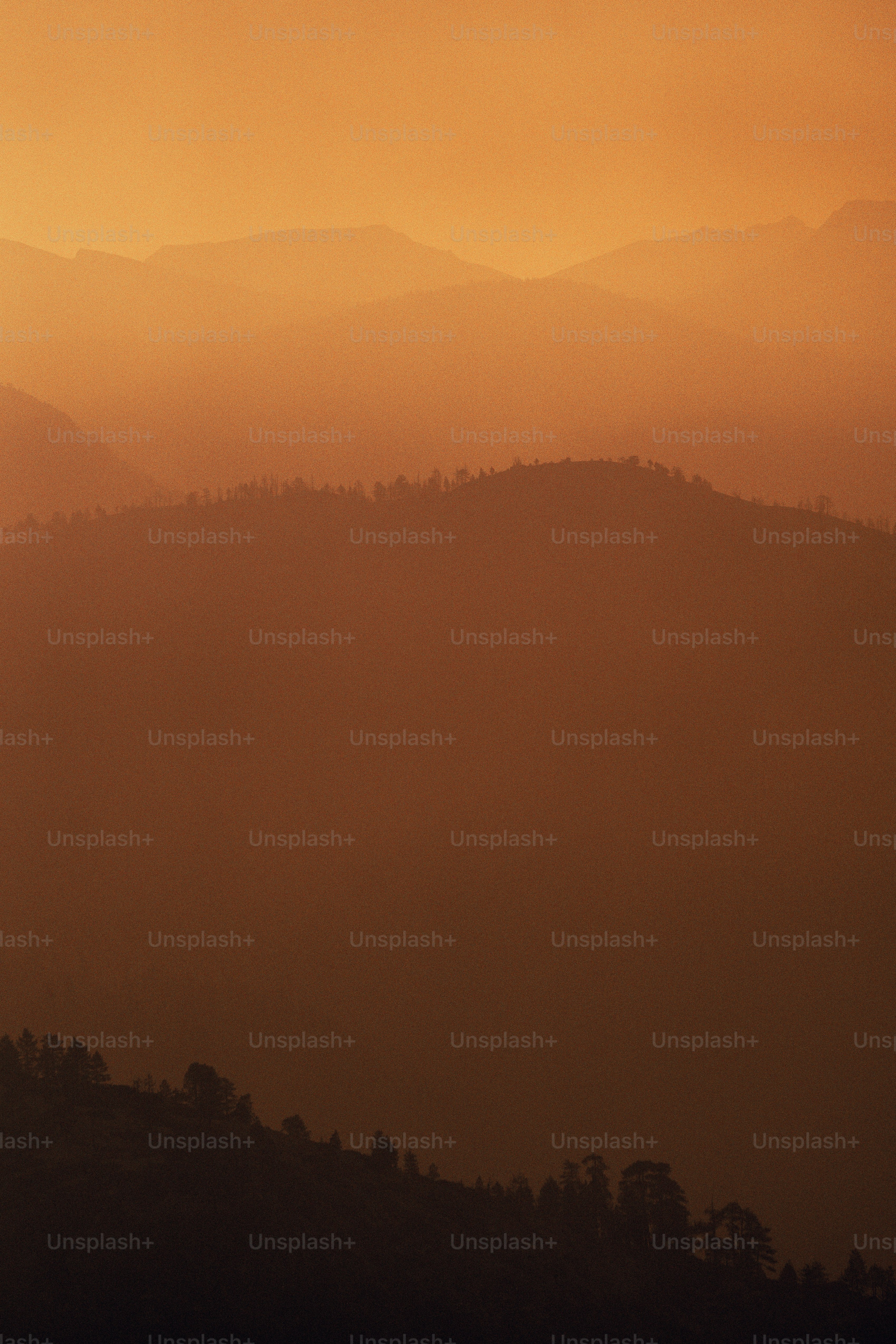 A hazy view of a mountain range with trees photo – Heat Image on Unsplash