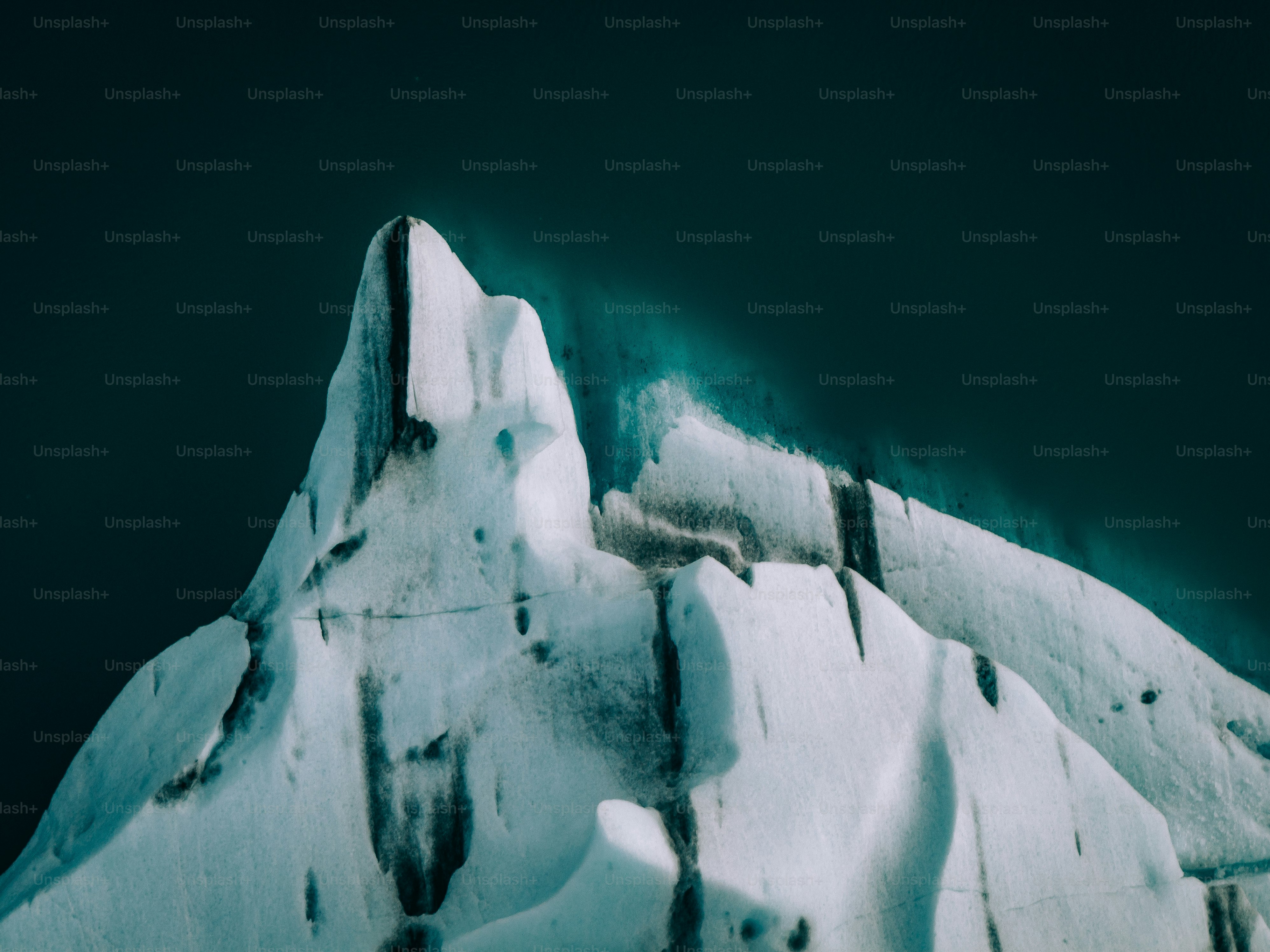 A large iceberg with snow on the side of it photo – Freeze Image on ...
