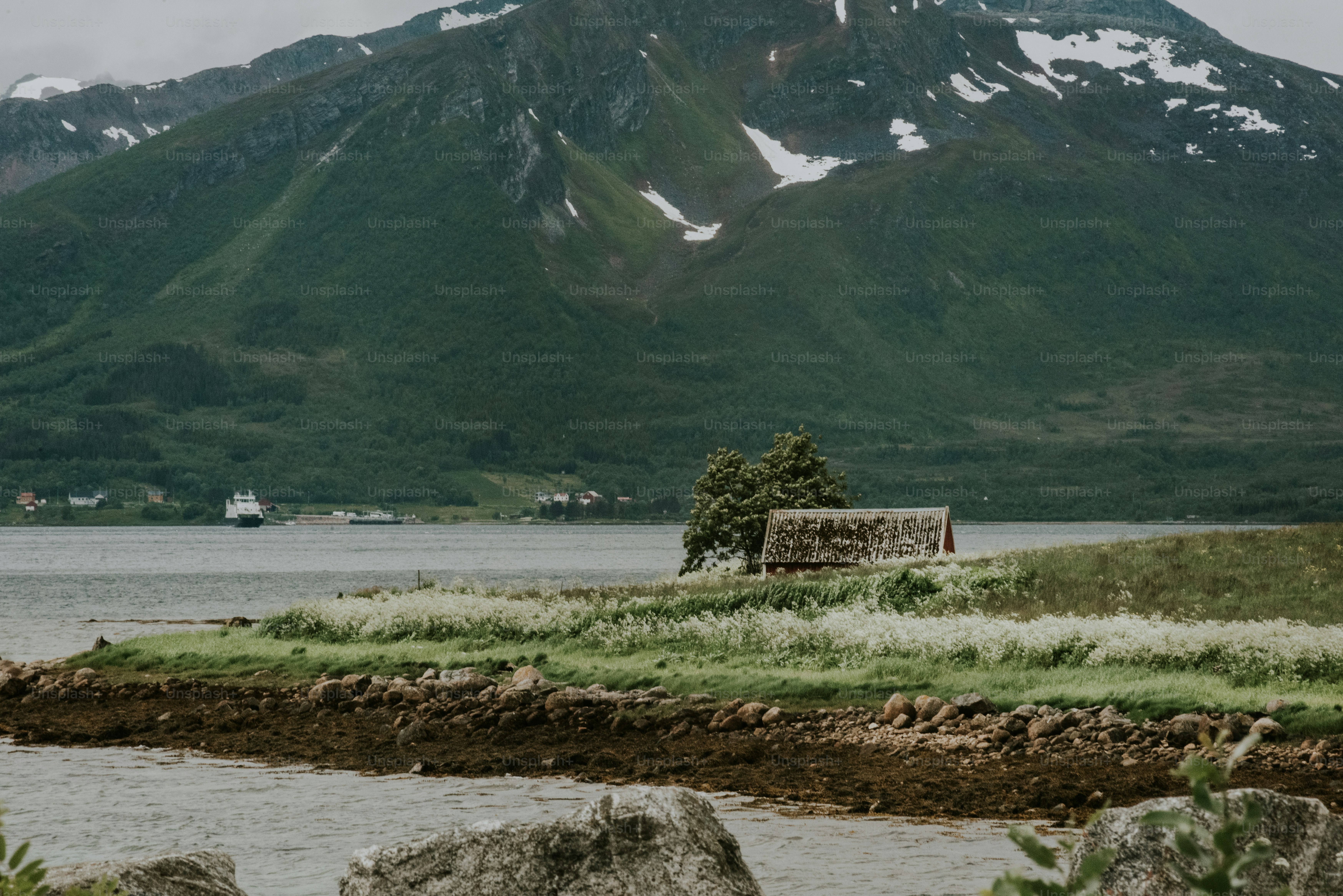 A small hut sitting on a small island in the middle of a lake photo ...