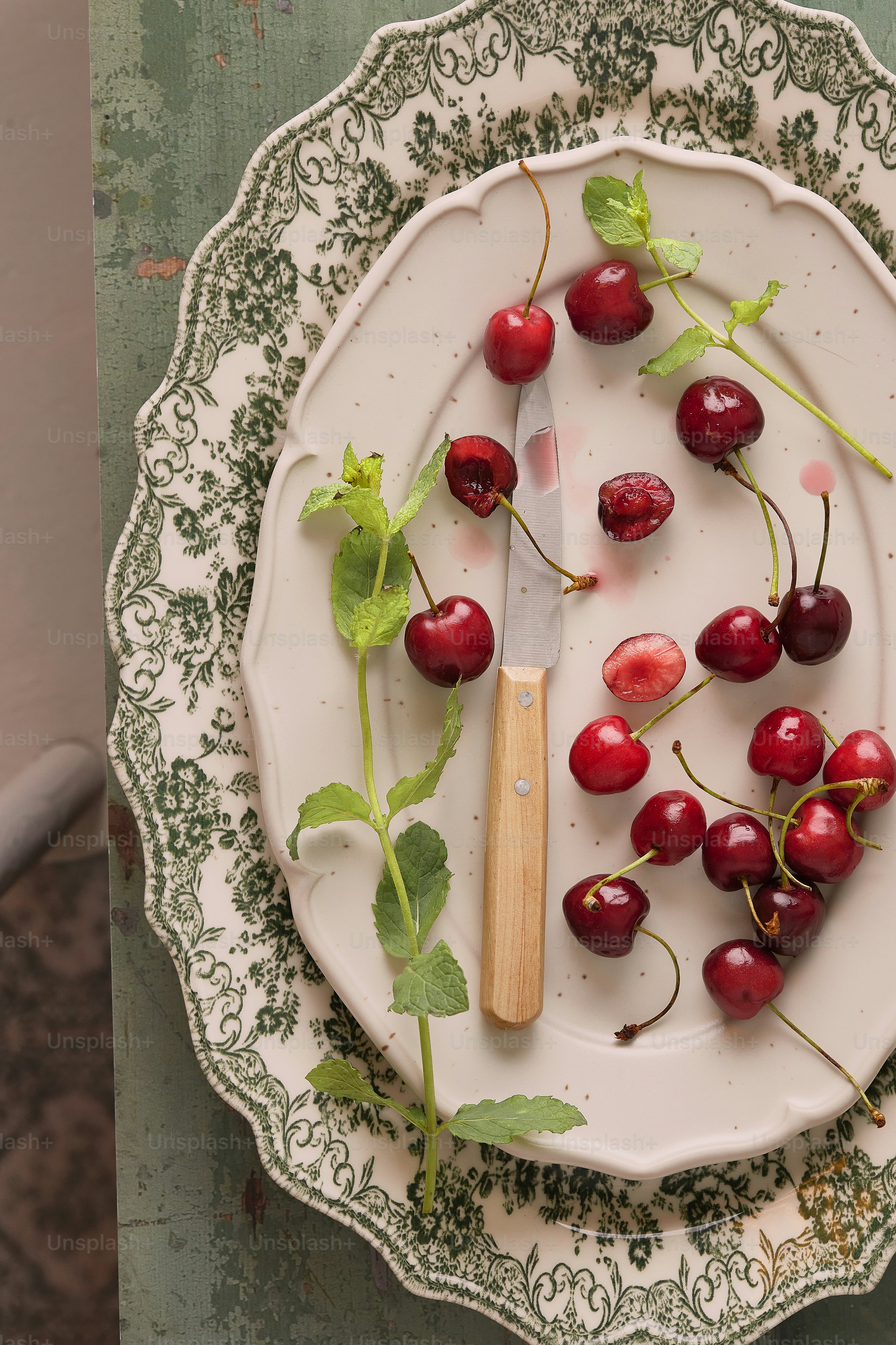 A plate with cherries on it sitting on a table photo – Summer fruit ...