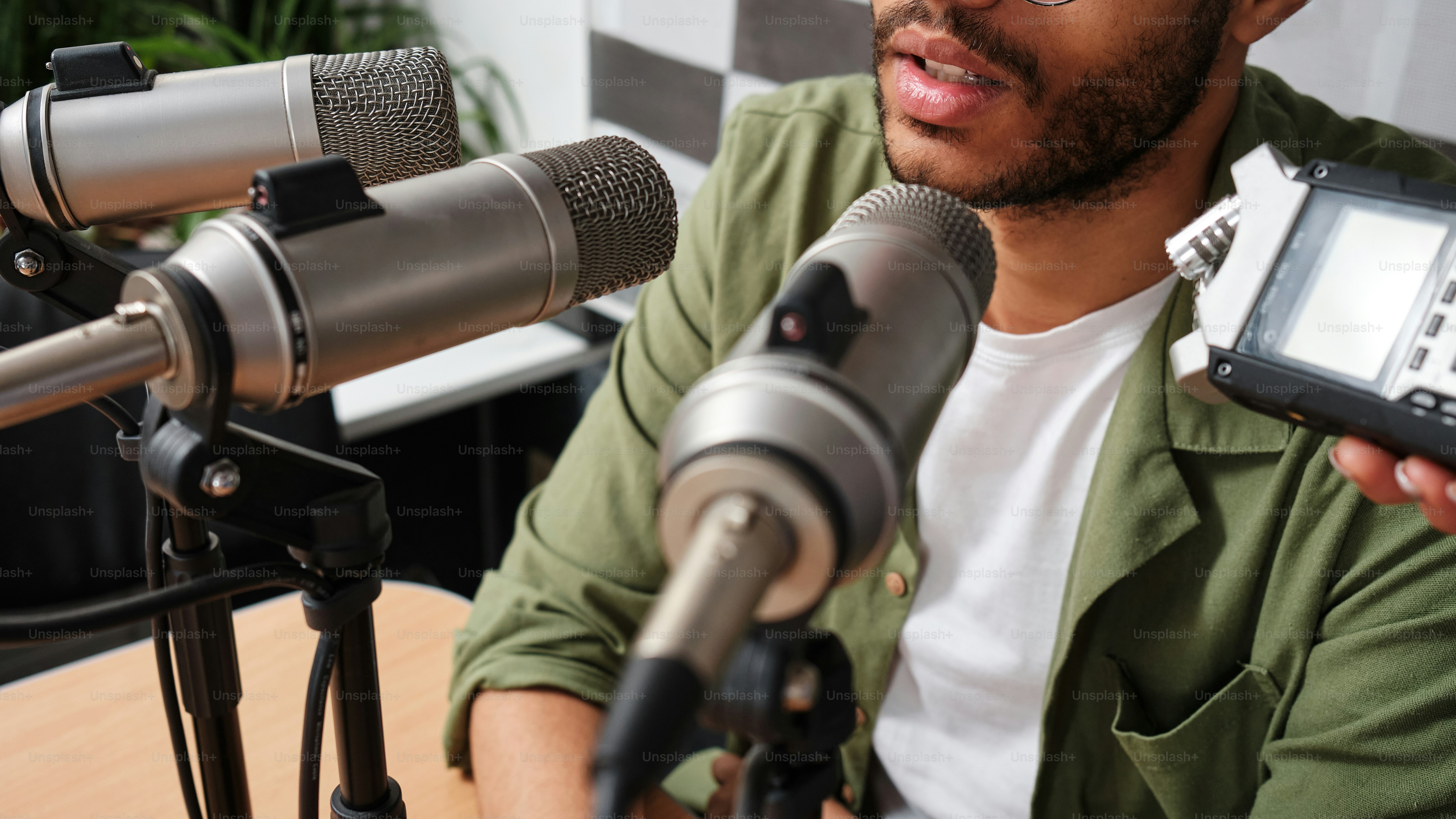 A man holding a cell phone in front of a microphone photo – Microphone ...
