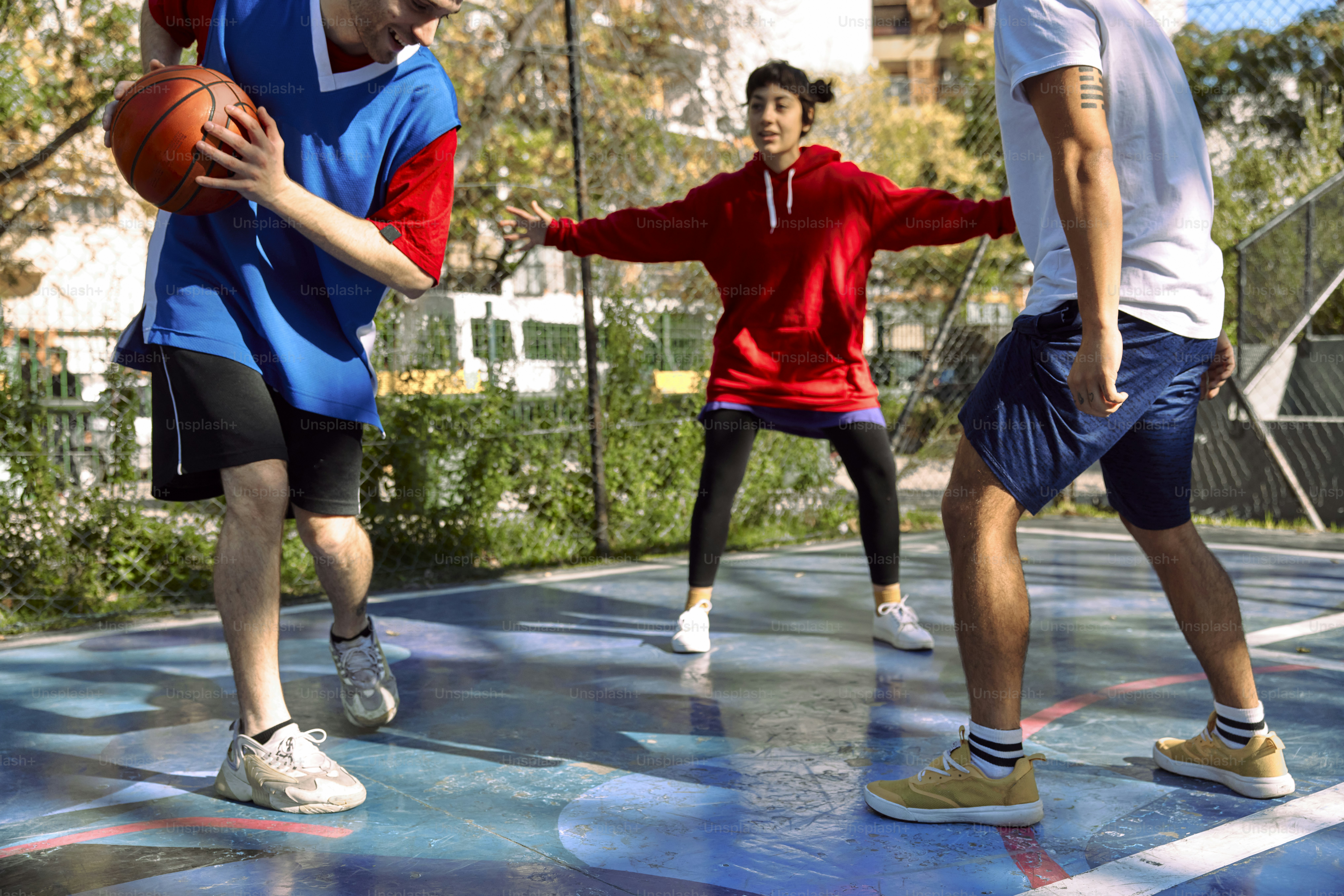A group of young men playing a game of basketball photo – Sports Image ...