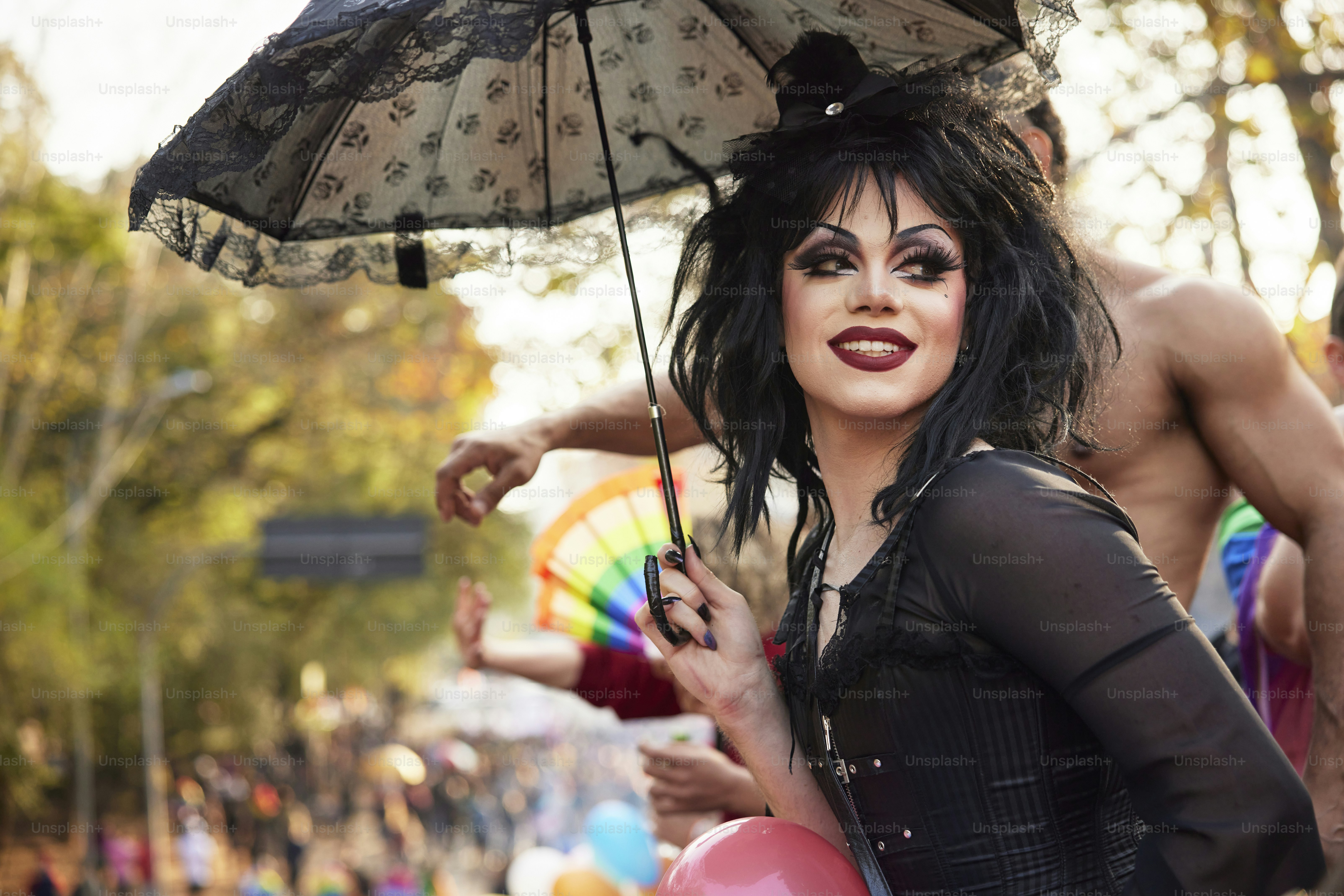 A woman holding an umbrella in a parade photo – Goth Image on Unsplash