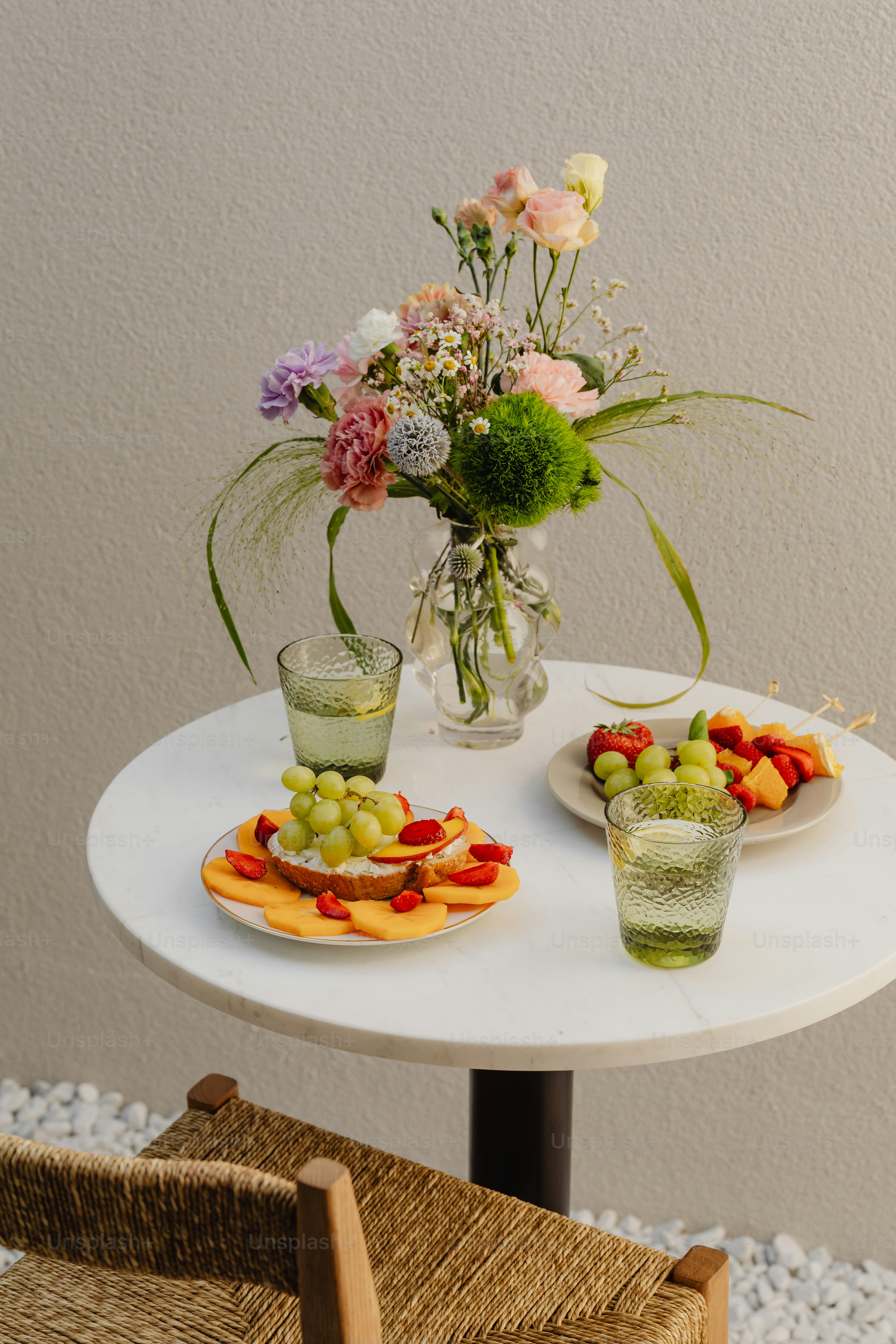 A white table topped with plates of fruit and flowers photo – Summer ...