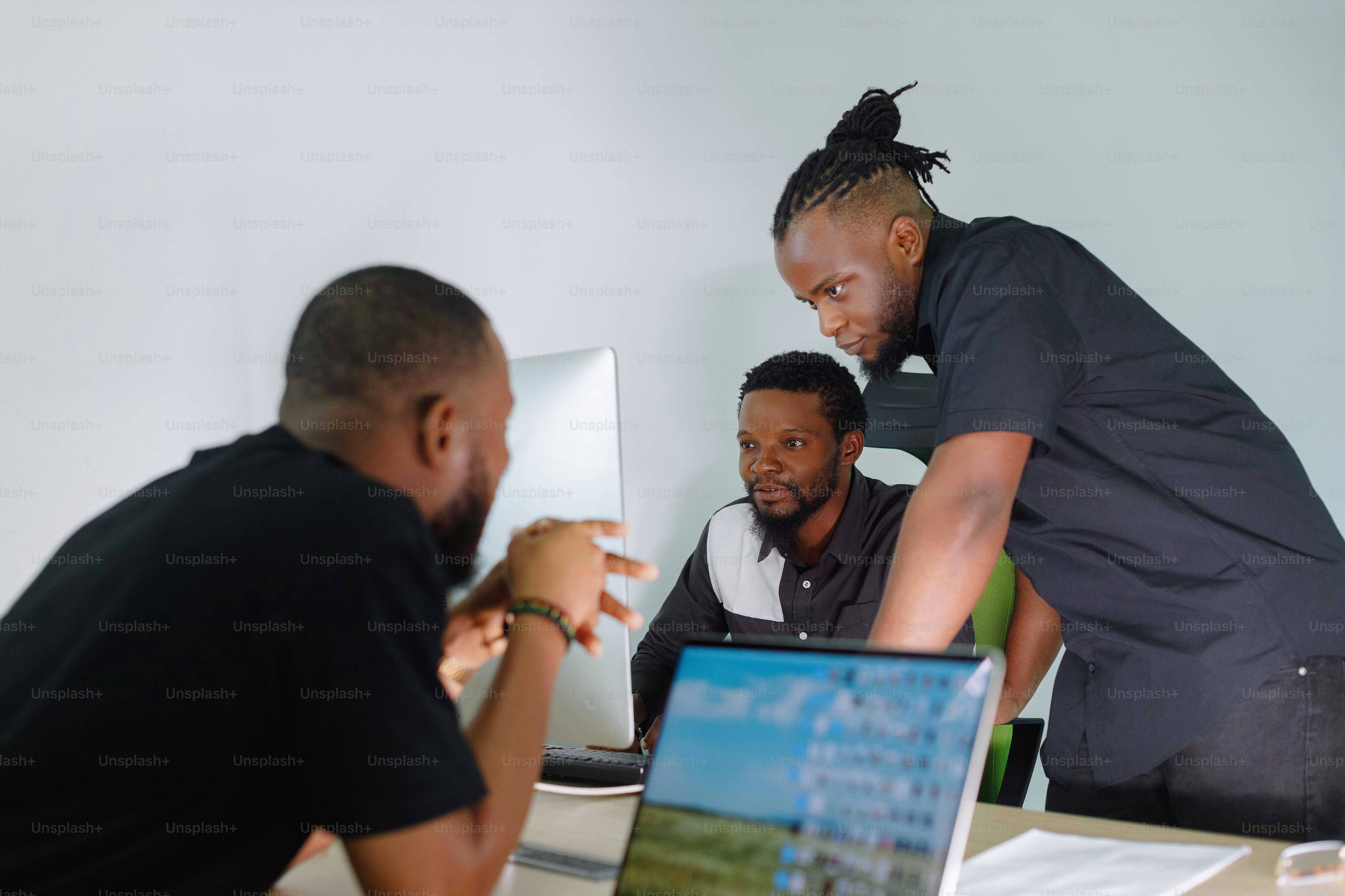 Two men looking at a laptop computer screen photo – Web development ...