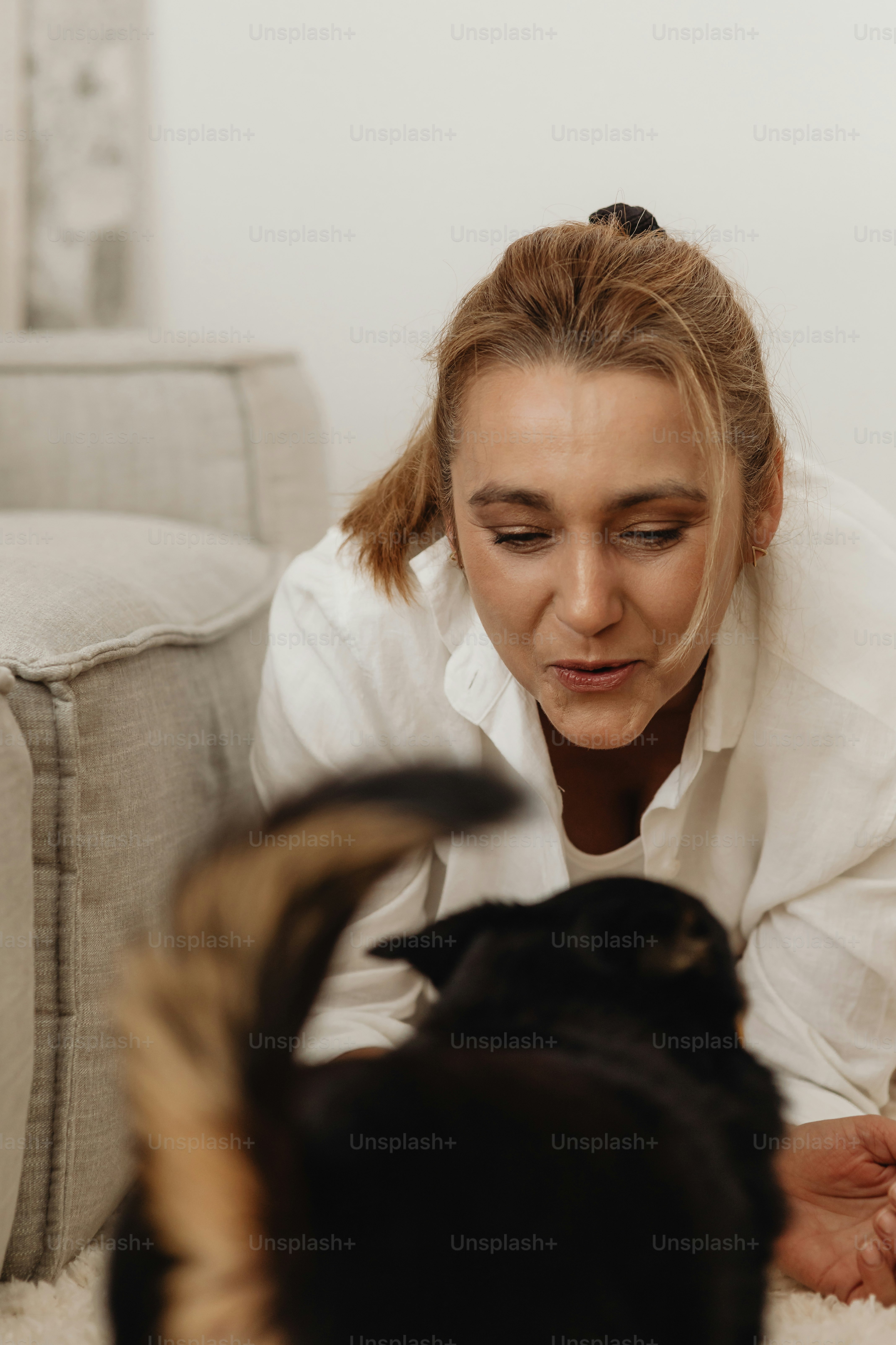 Foto Una mujer tendida en el suelo acariciando a un perro – Momentos ...