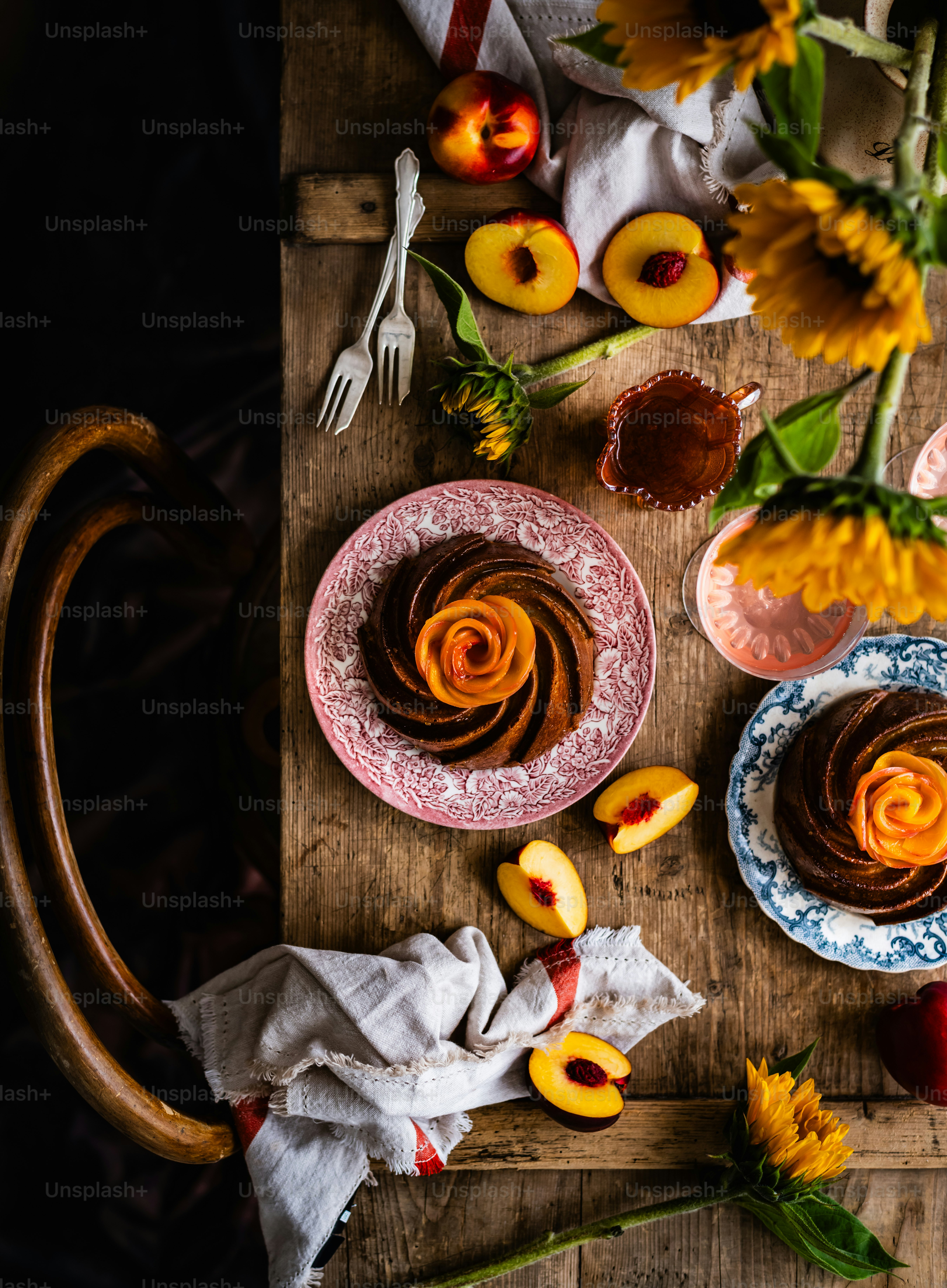 A wooden table topped with plates of food and flowers photo – Food ...