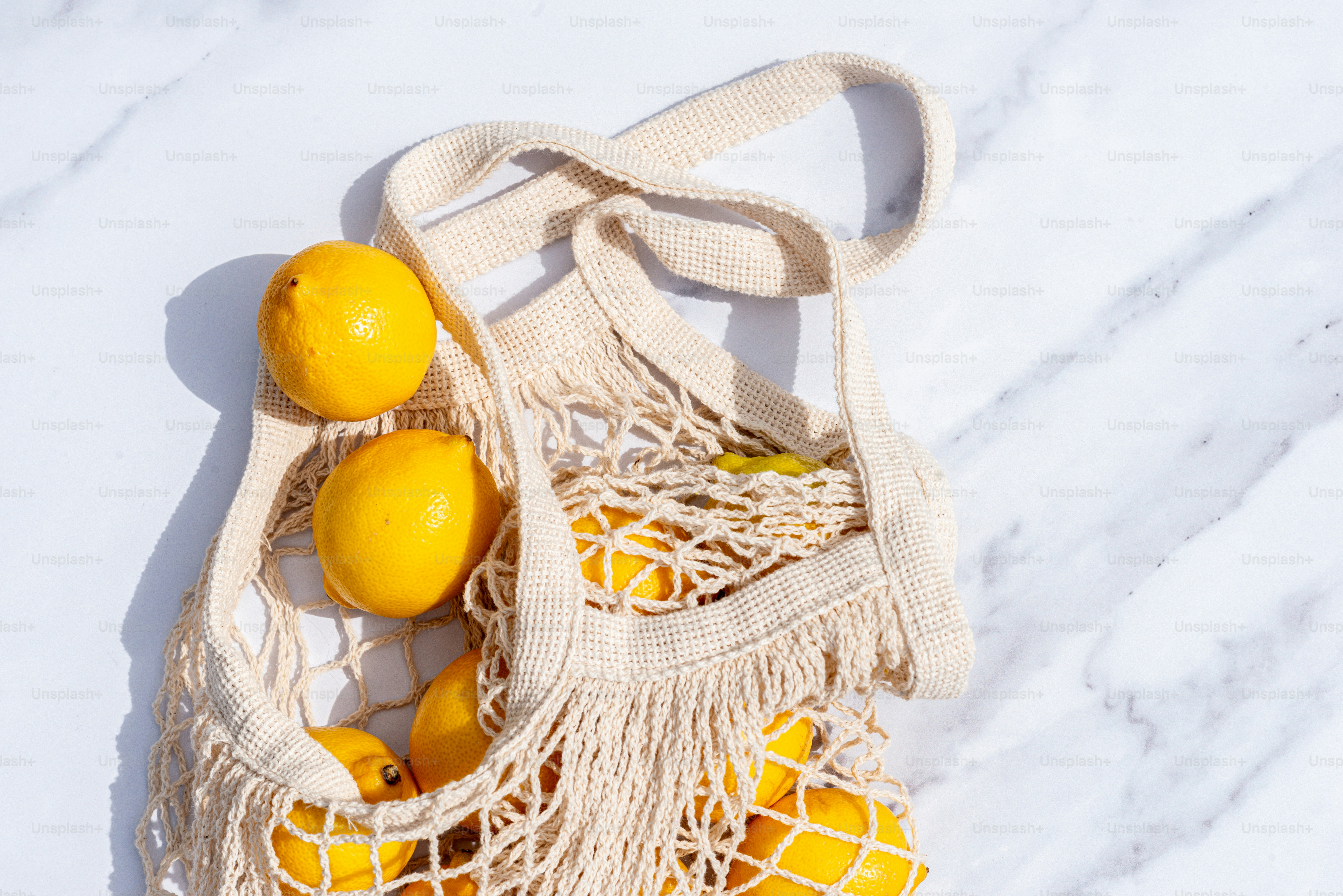A bag of lemons sitting on top of a white counter photo – Seasonal food ...