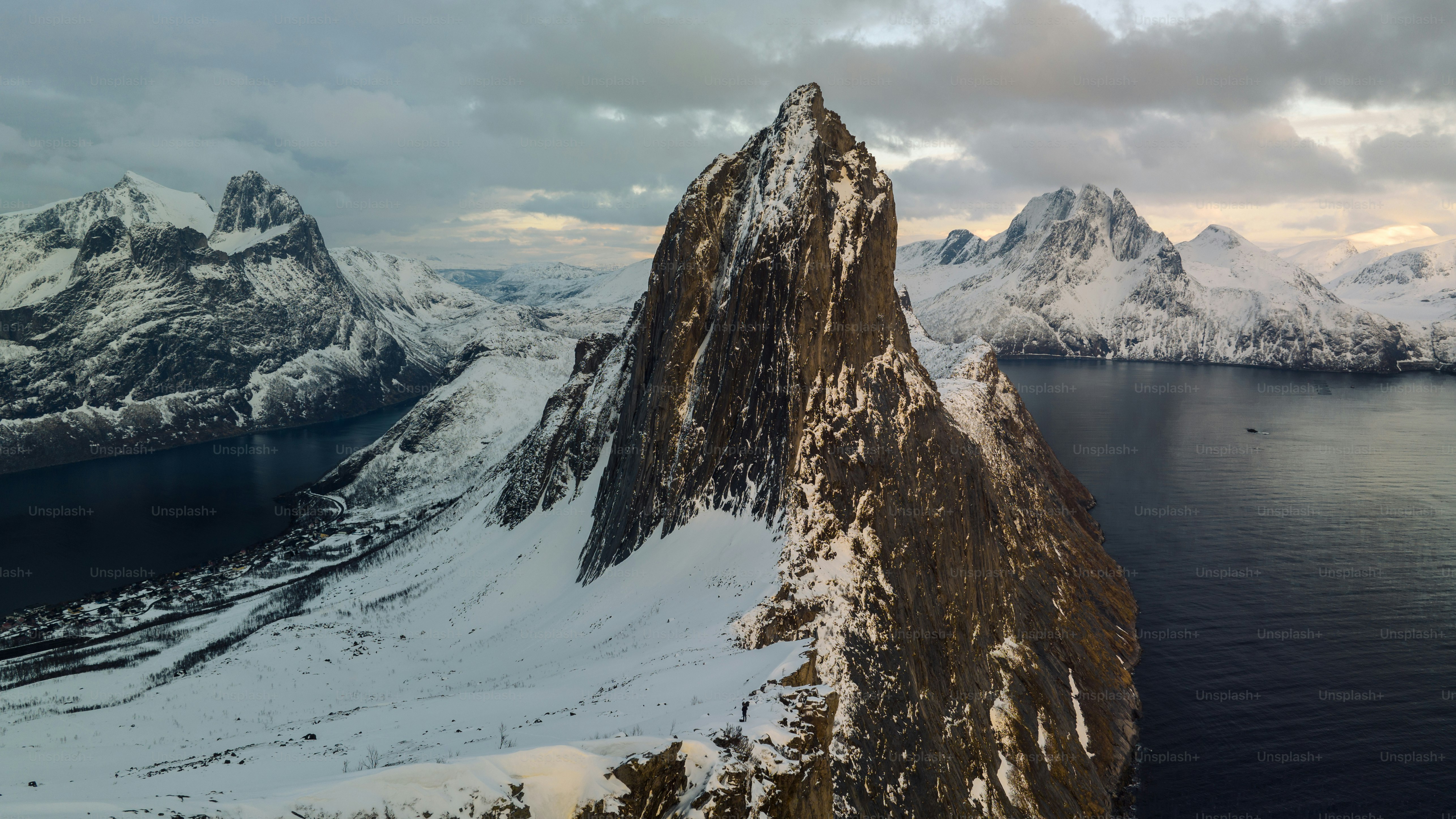 Ein schneebedeckter Berg mit einem See und Bergen im Hintergrund Foto ...