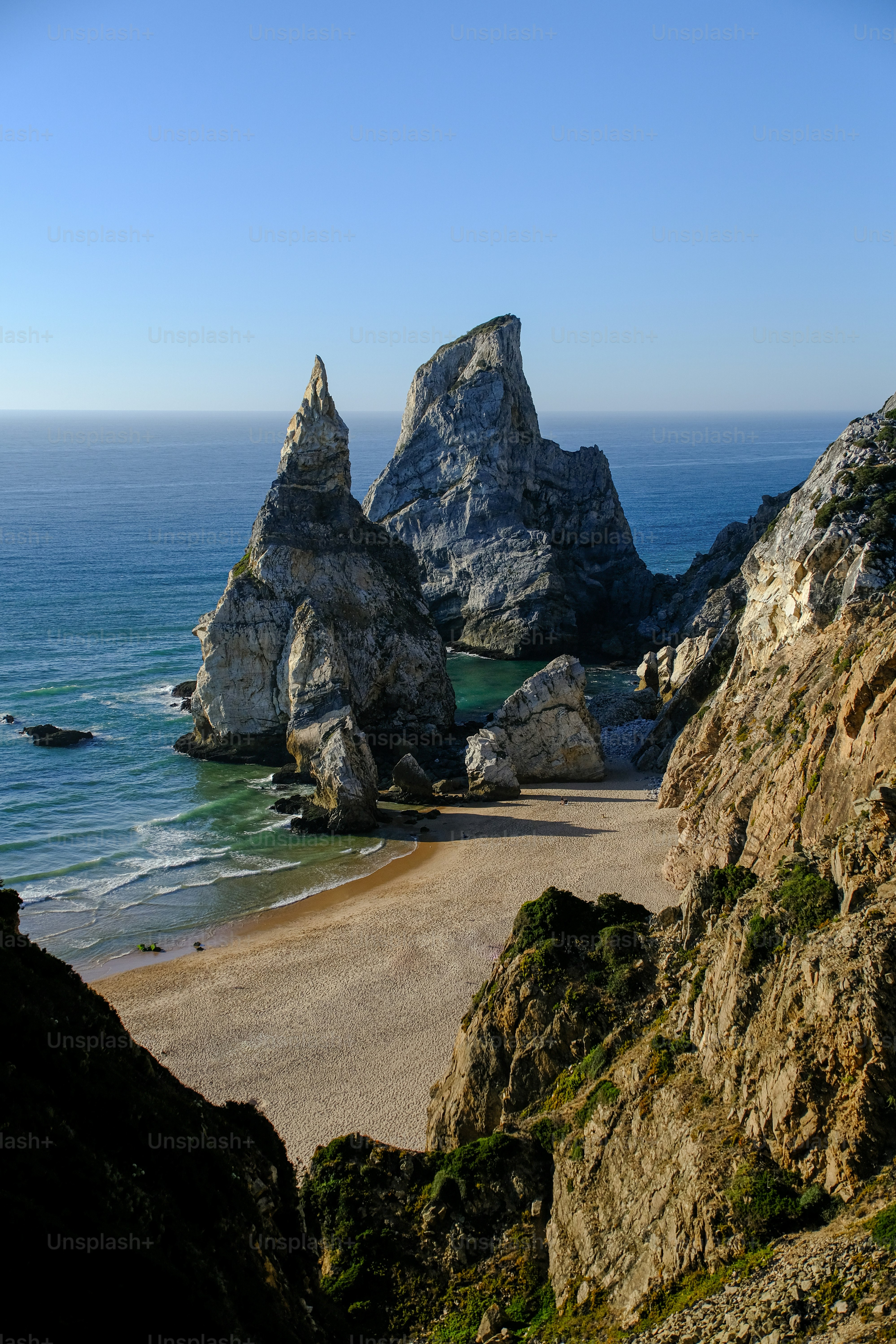 Ein felsiger Strand mit ein paar Felsen, die aus dem Wasser ragen Foto ...